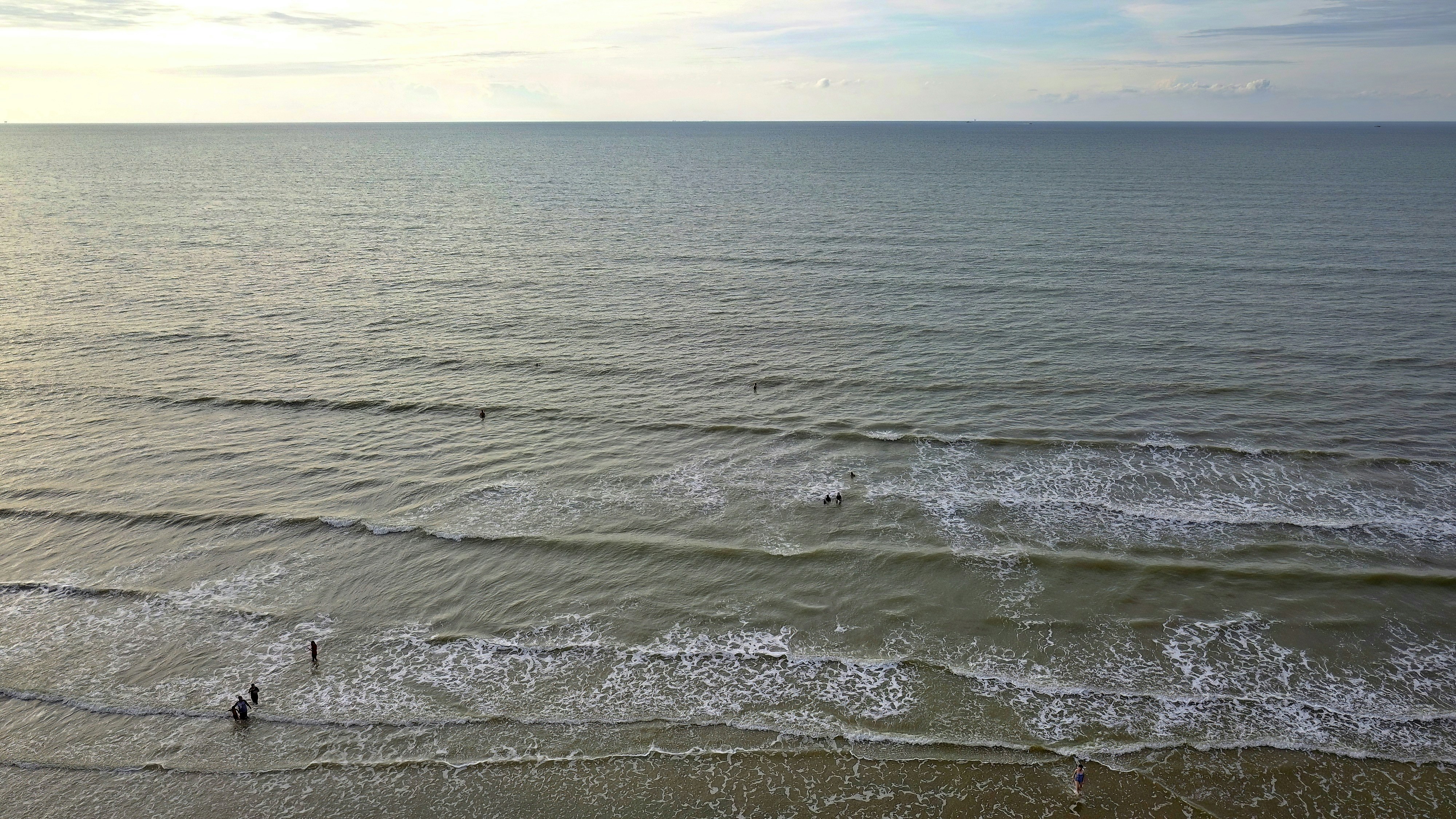 Waves gently crash on a sandy beach shore.