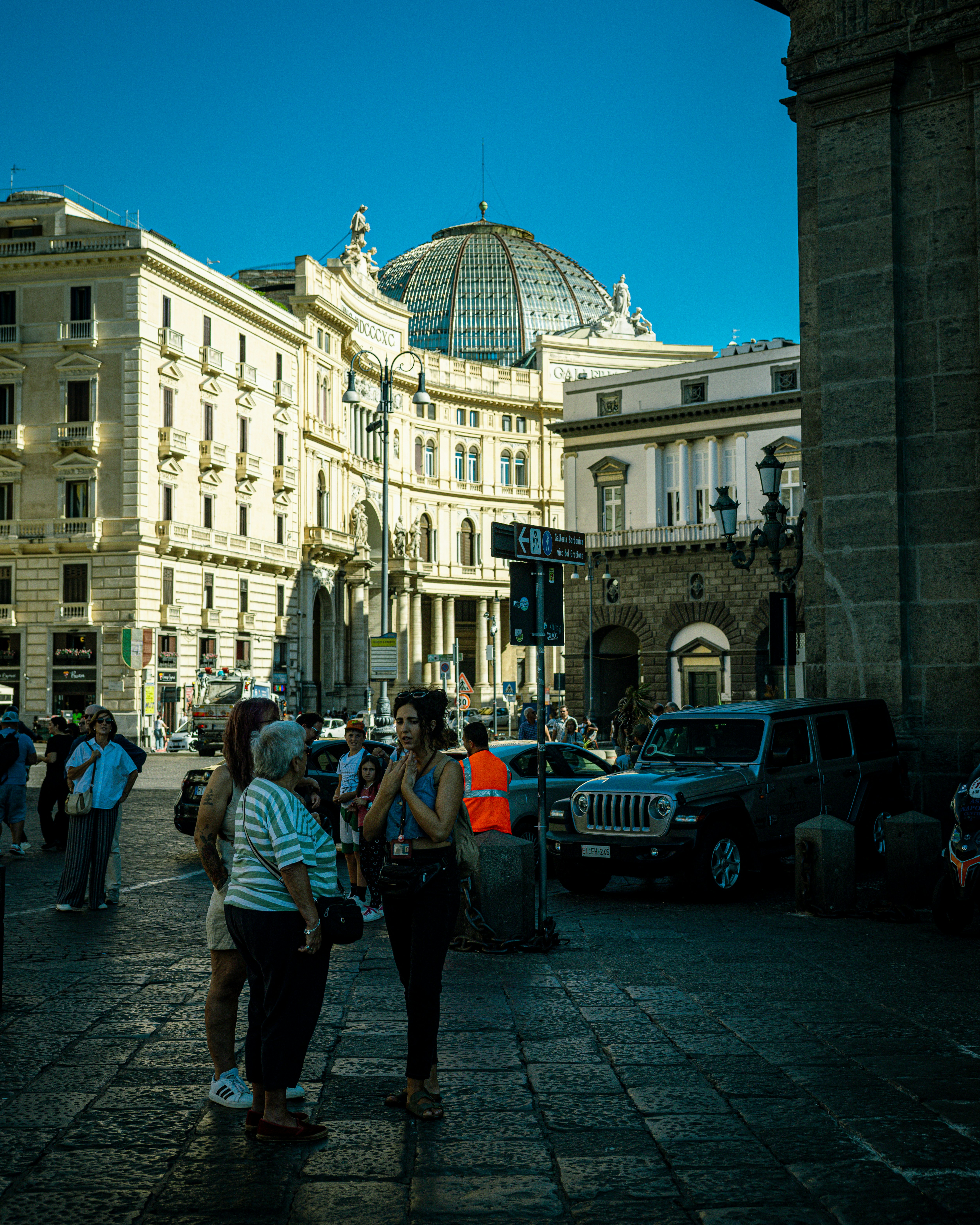 Piazza Confluence: Faces, a Car, and a Dome in Sunlit Stone