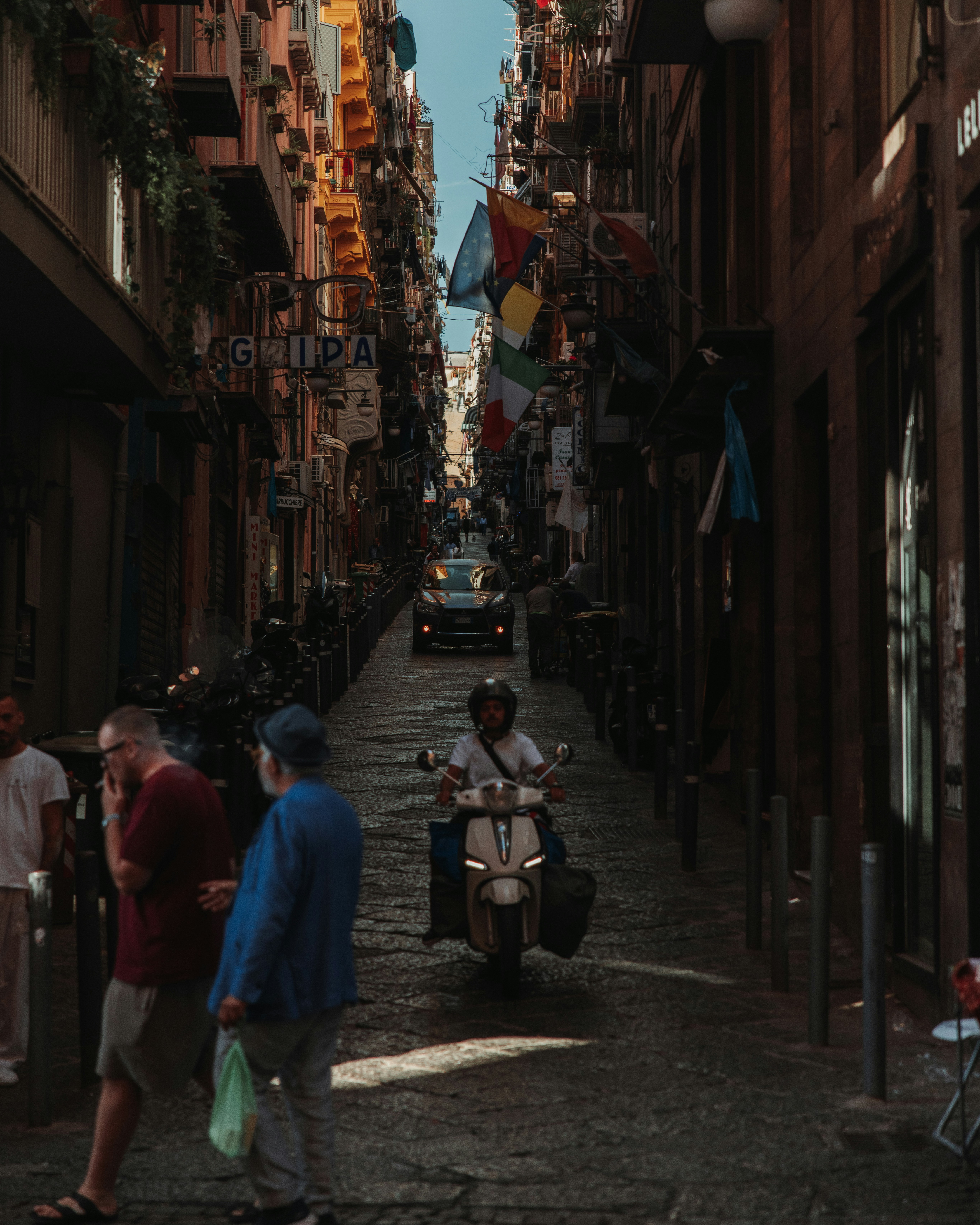 Narrow european street with buildings and a scooter.