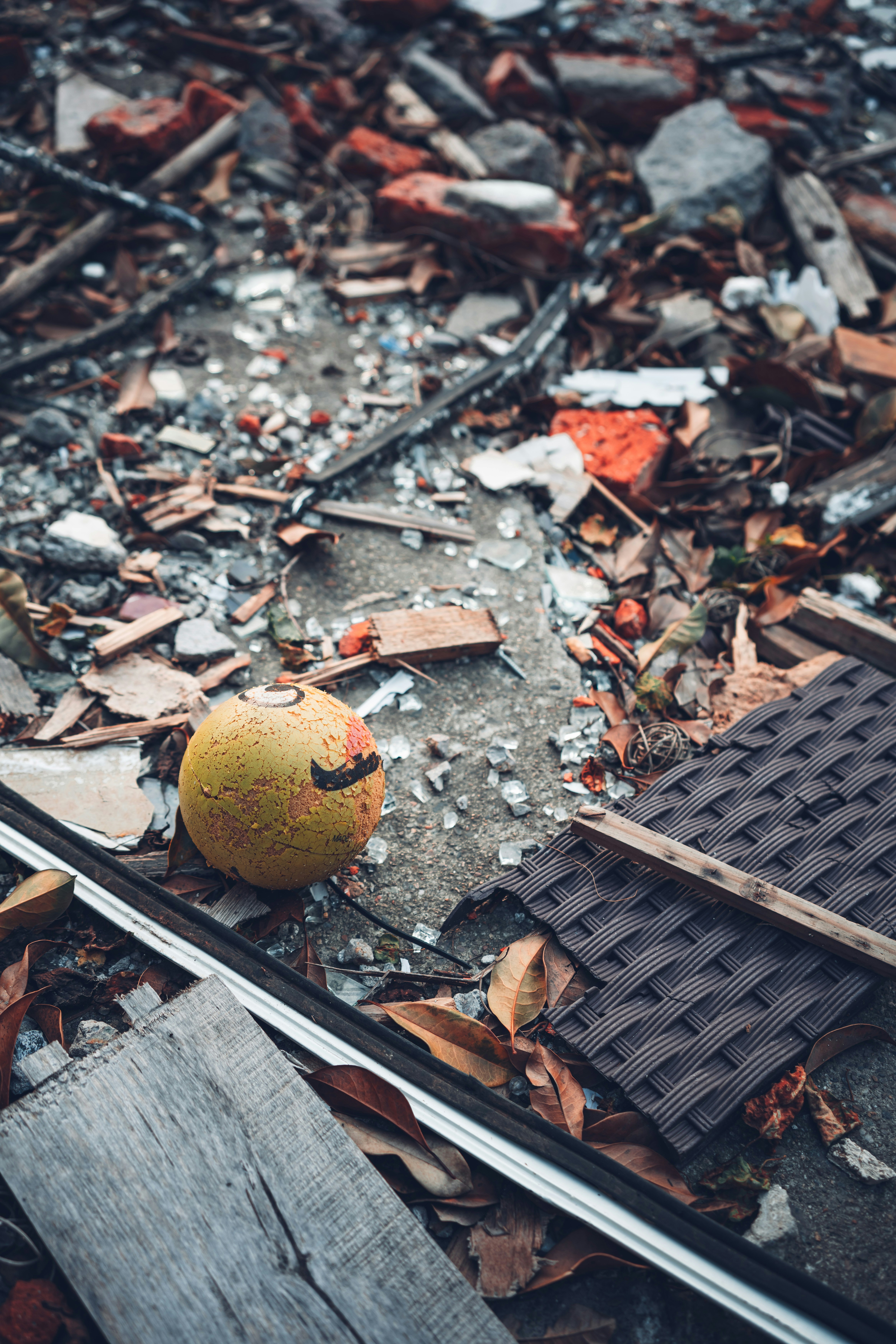 A yellow ball lies amidst rubble and debris