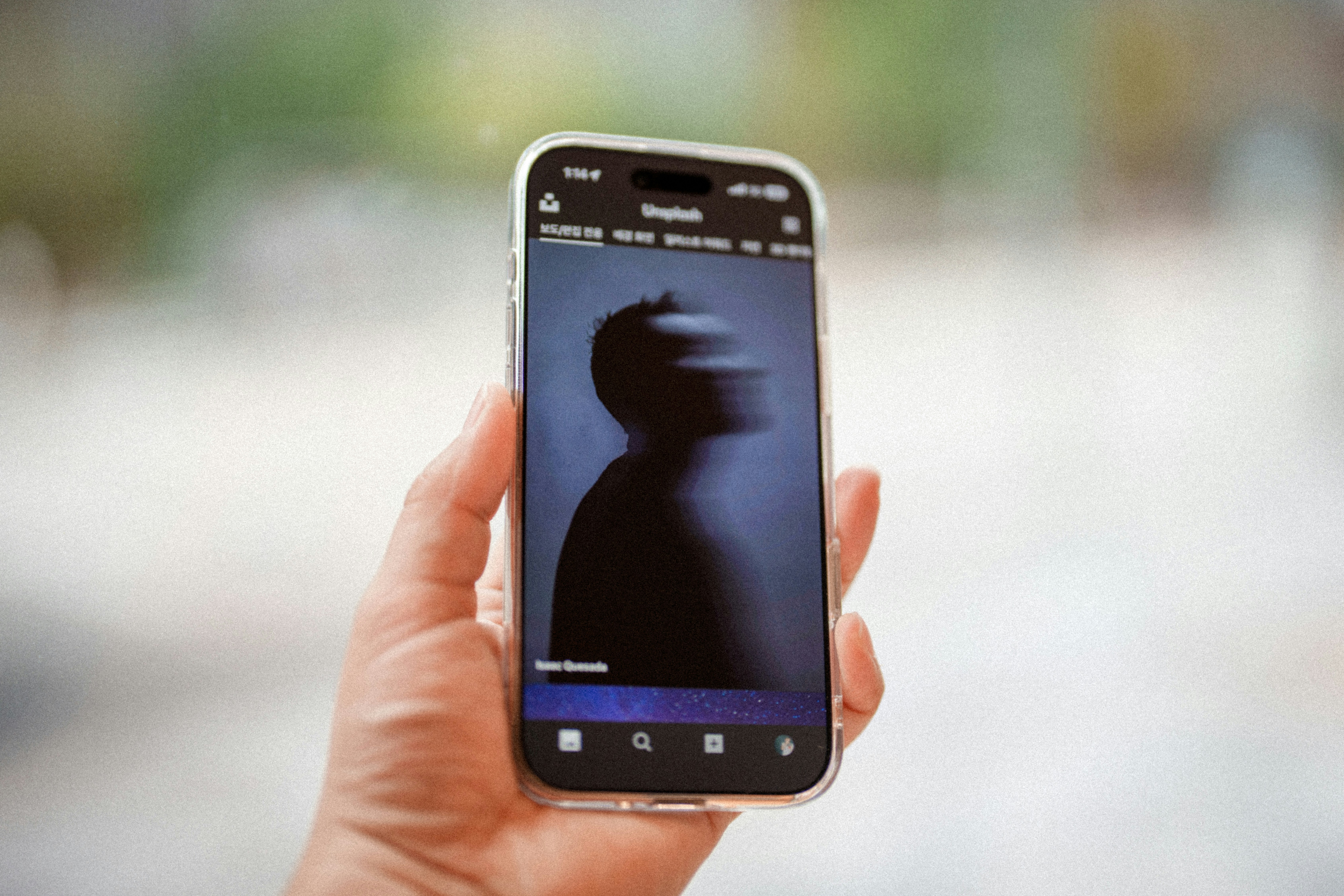 A blurred silhouette of a person displayed on a smartphone screen, representing the interplay between technology and human perception.