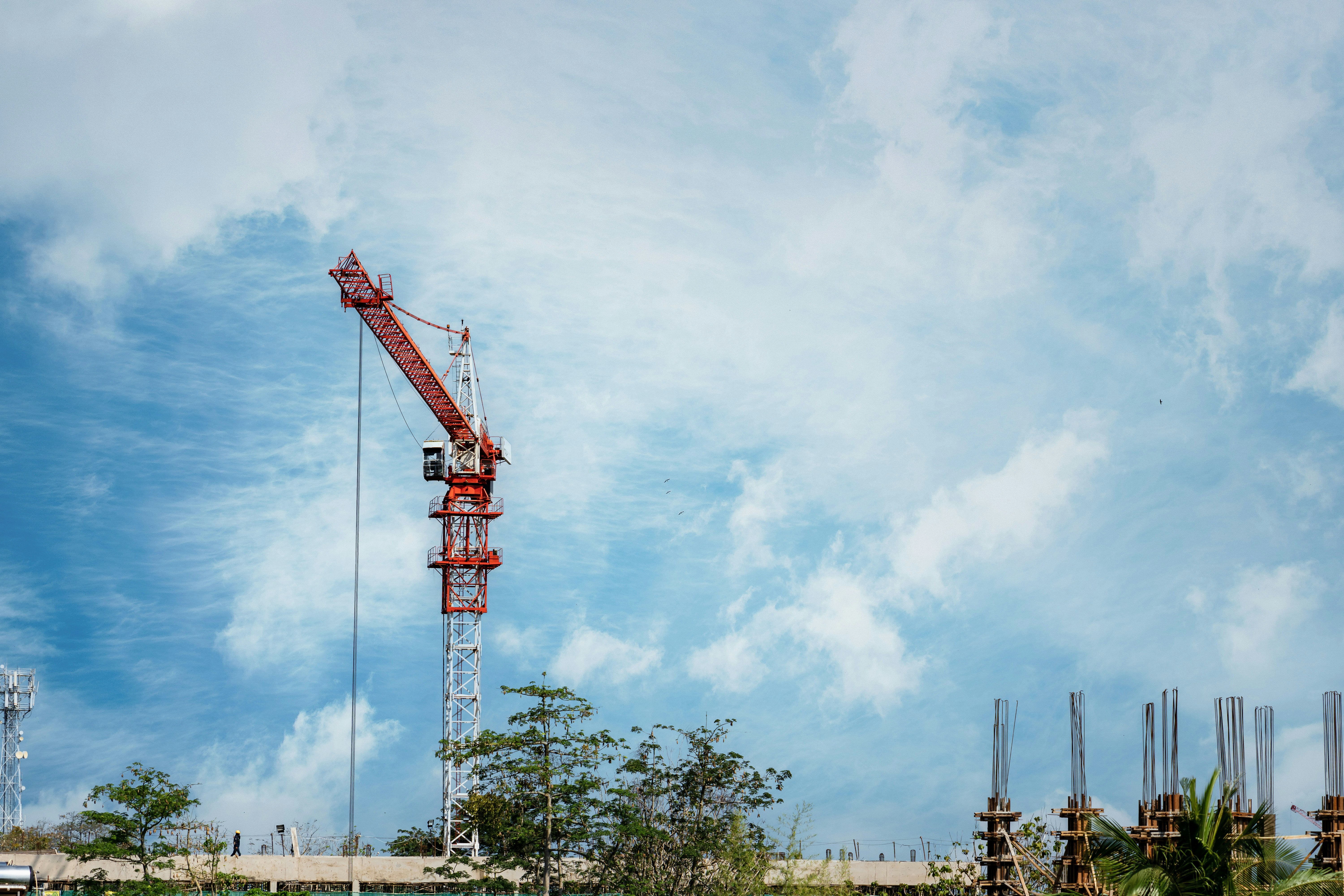 Construction crane against a cloudy blue sky.