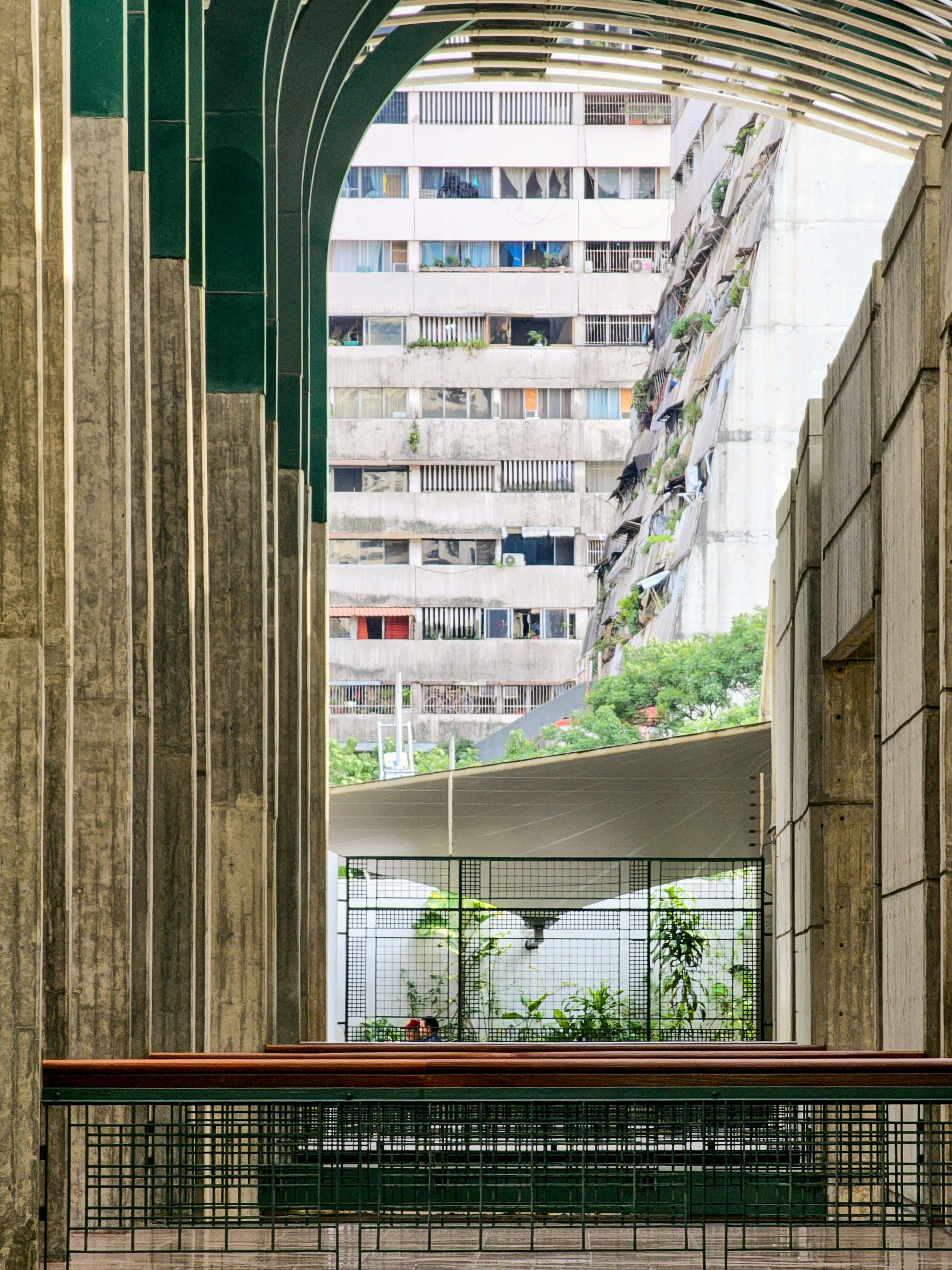 Modern concrete architecture with greenery and buildings.