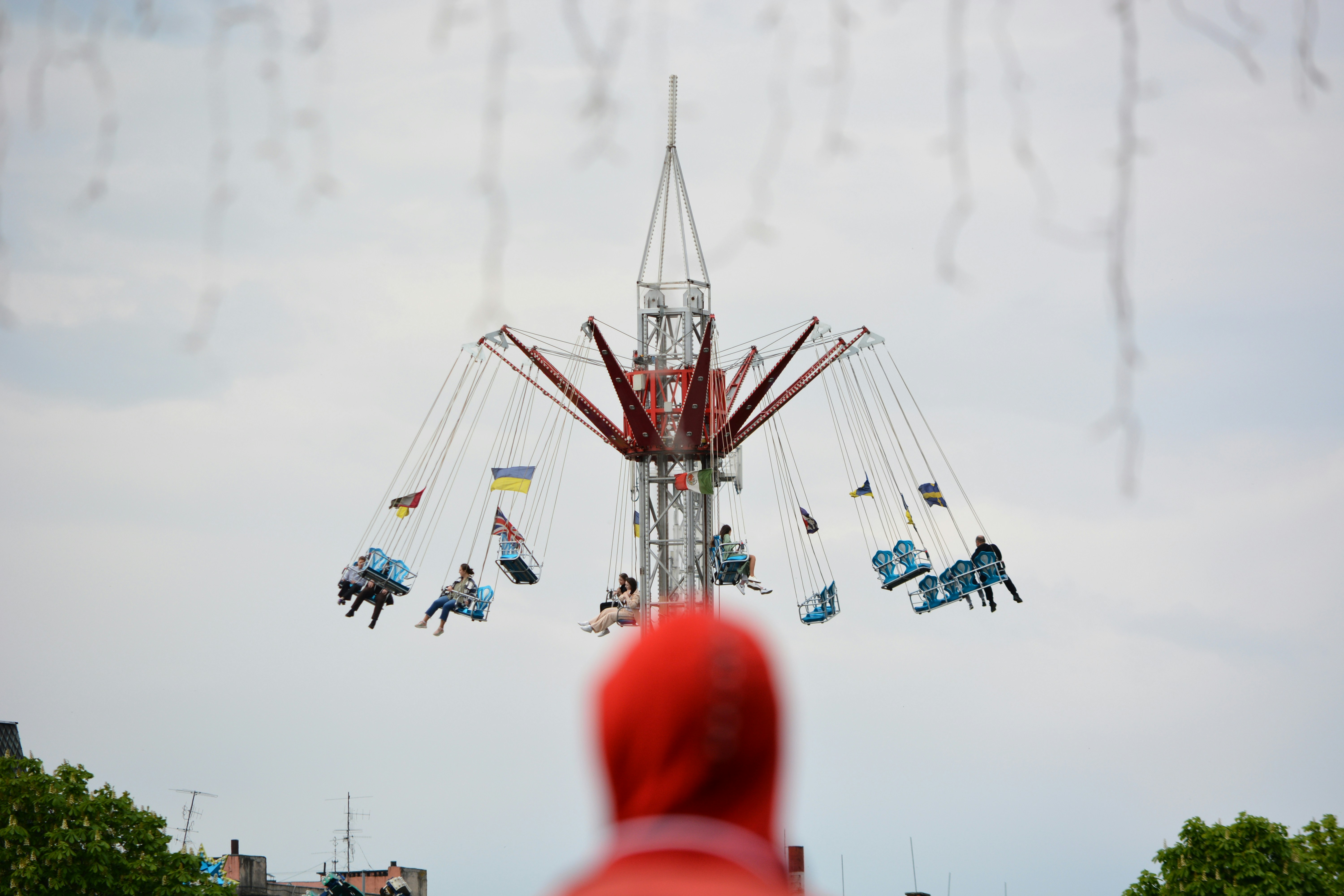 People riding a swing carousel ride at an amusement park.