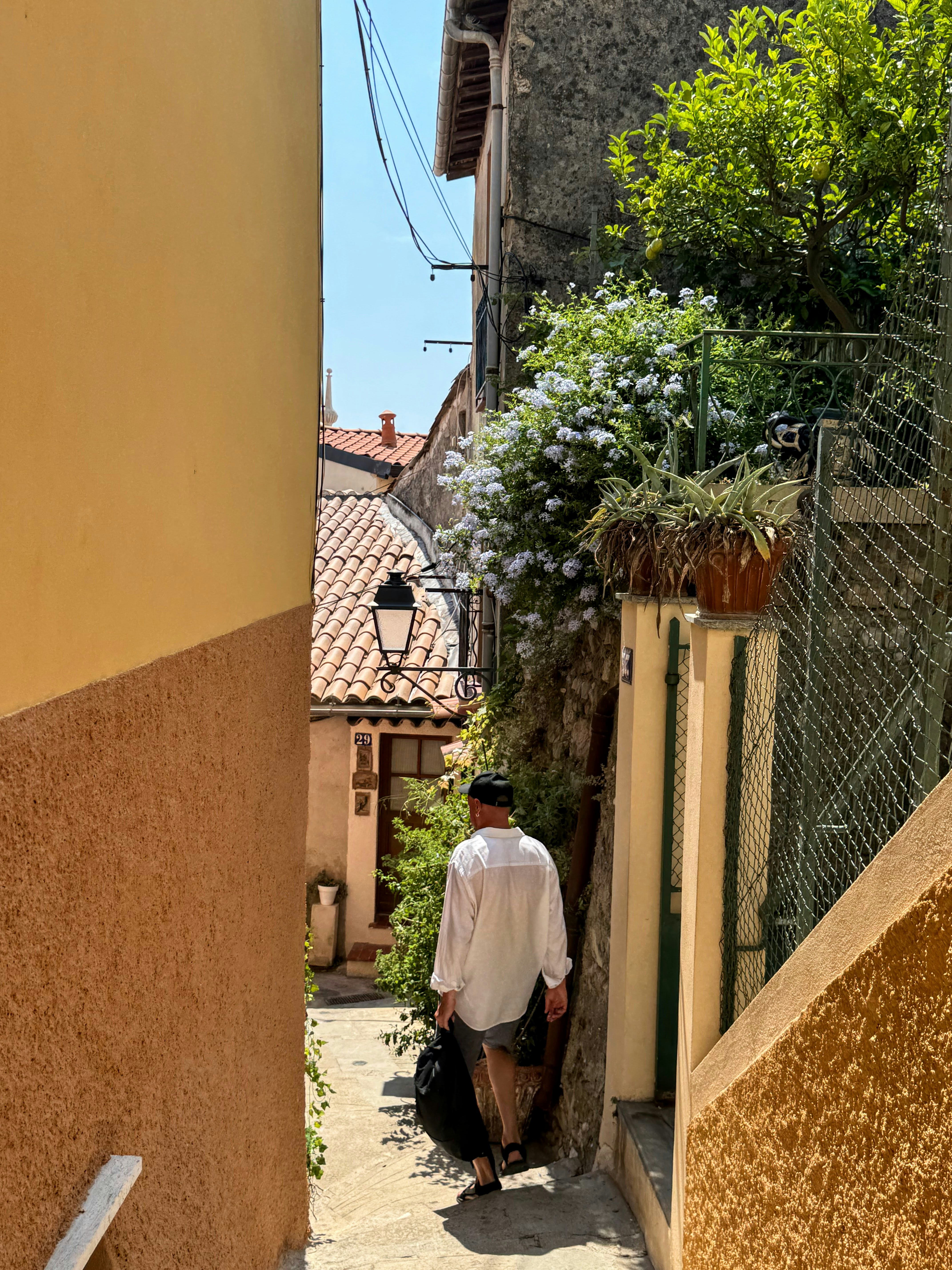 Man walks down narrow sunlit european street