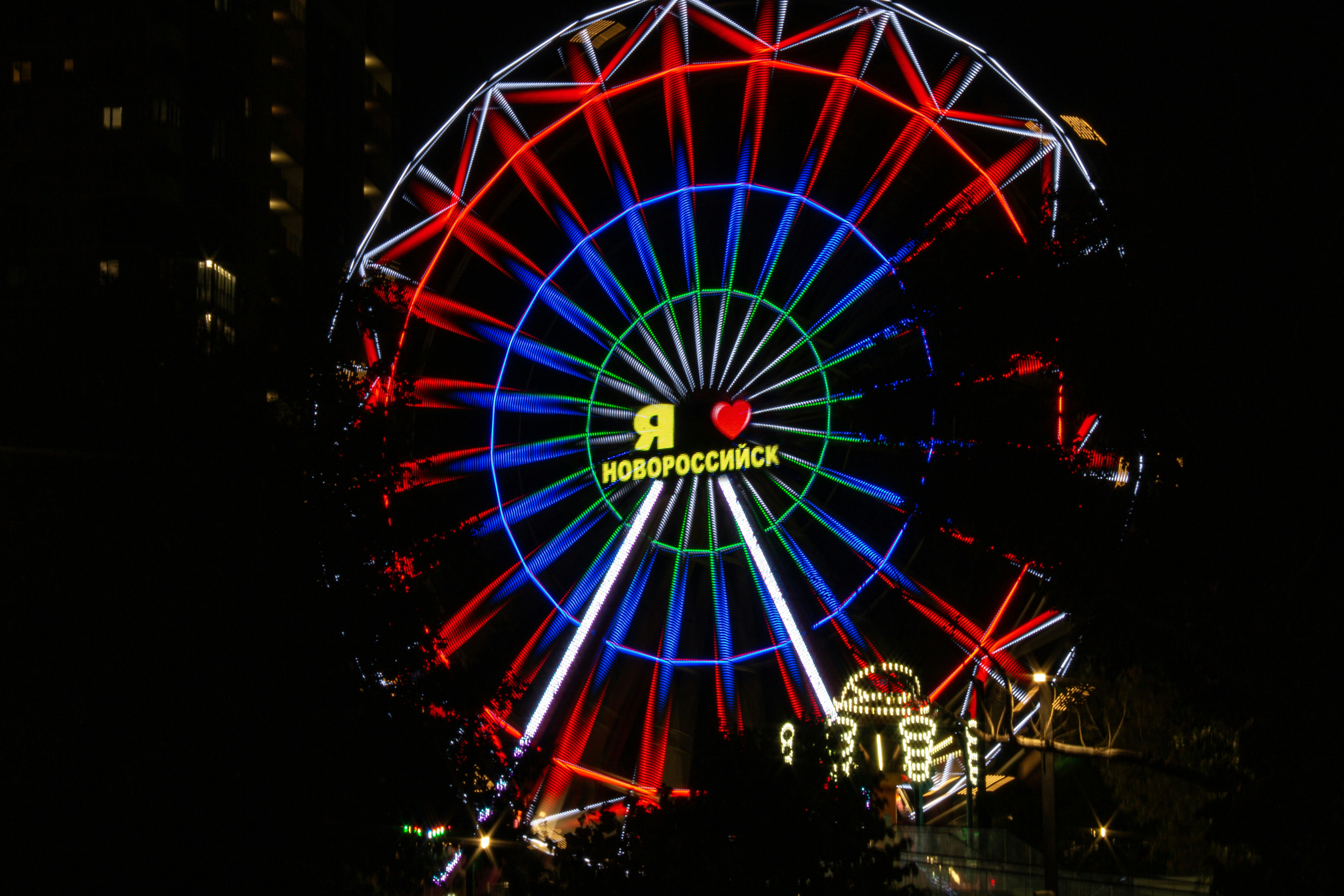Bright ferris wheel illuminated with colorful lights at night