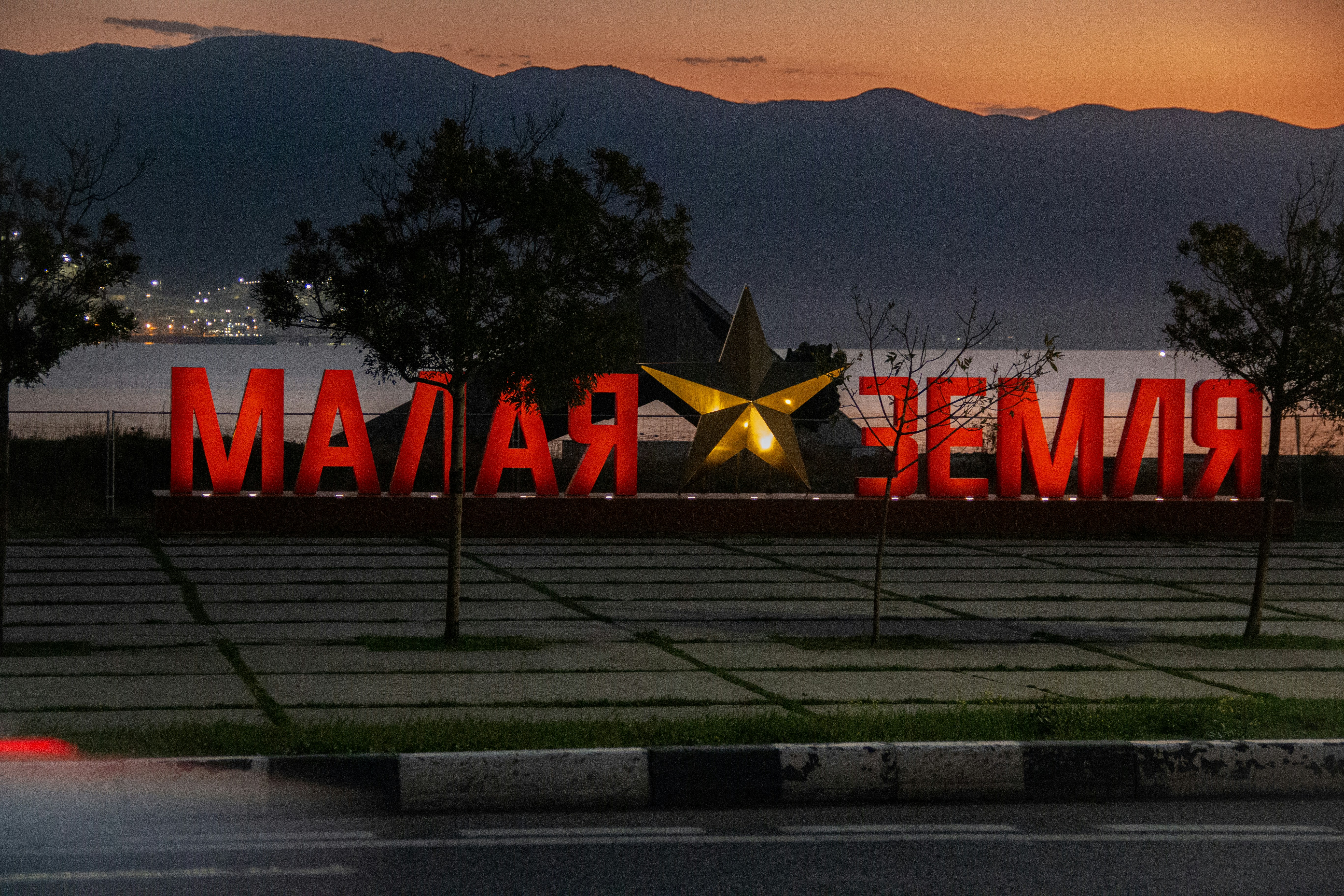 Large red letters spell "malaya zemlya" with a star.