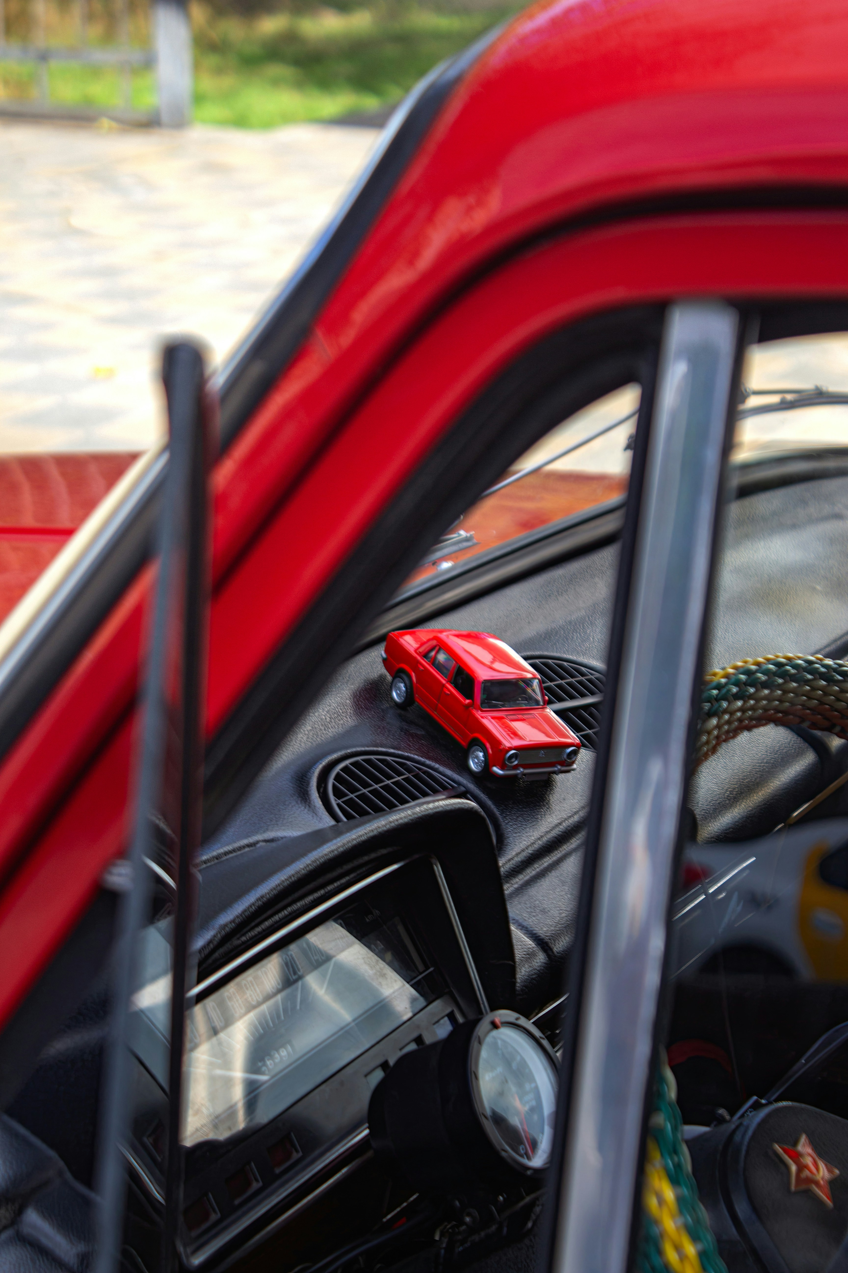 Tiny Red Toy Car on a Vintage Dashboard: A Micro Perspective Inside a Car Cabin