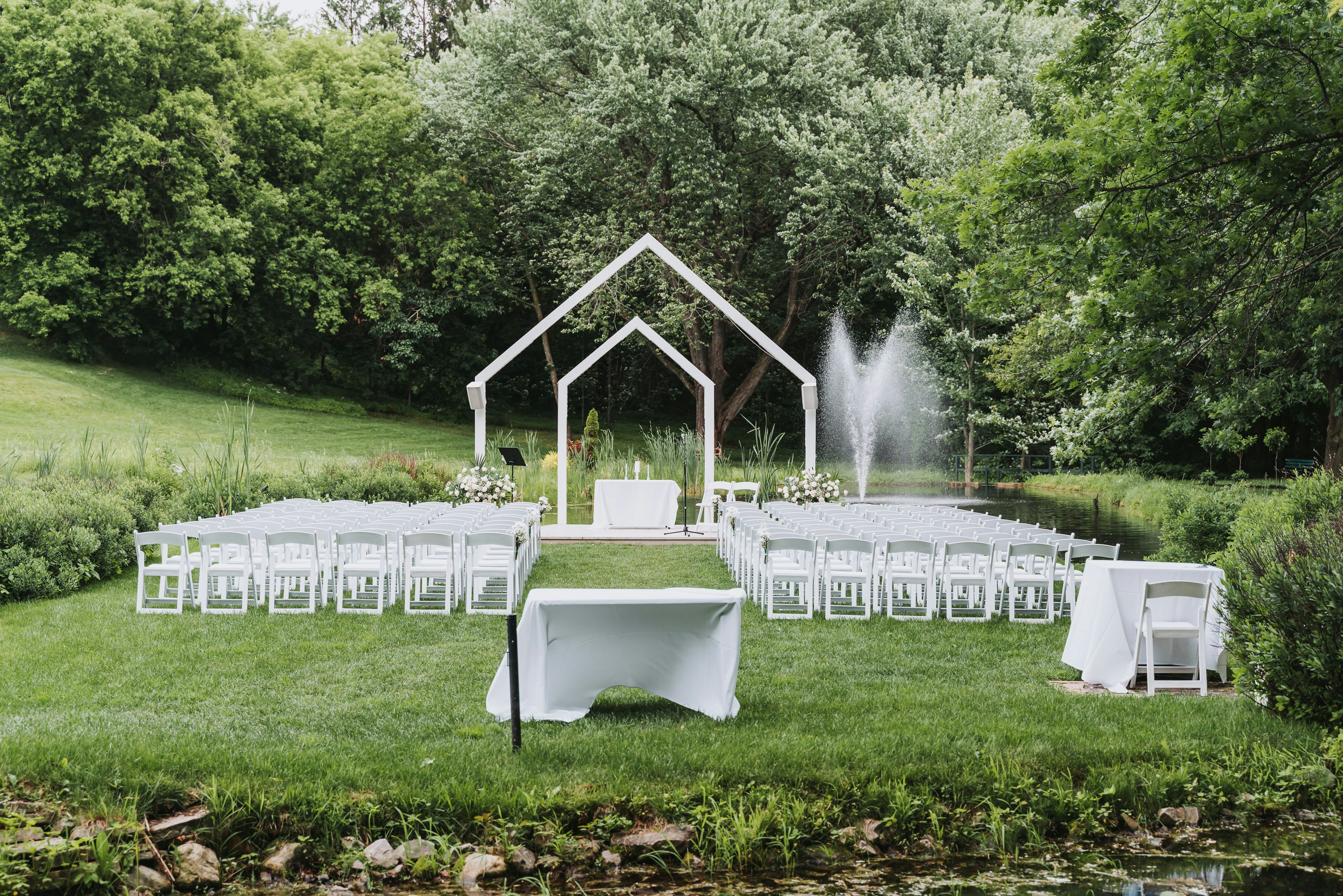 Outdoor wedding ceremony setup with white chairs and altar.