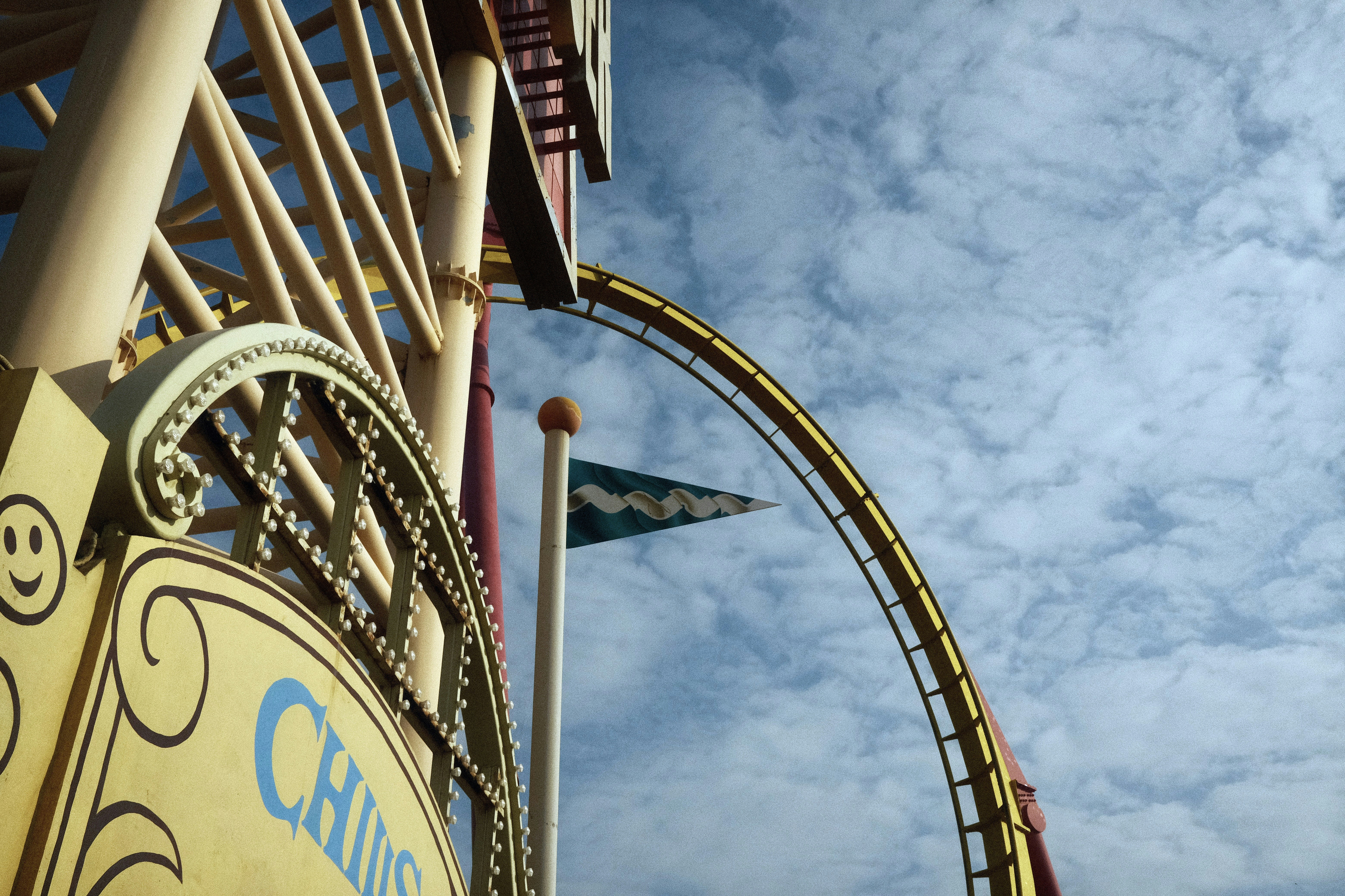 Roller coaster track against a cloudy sky