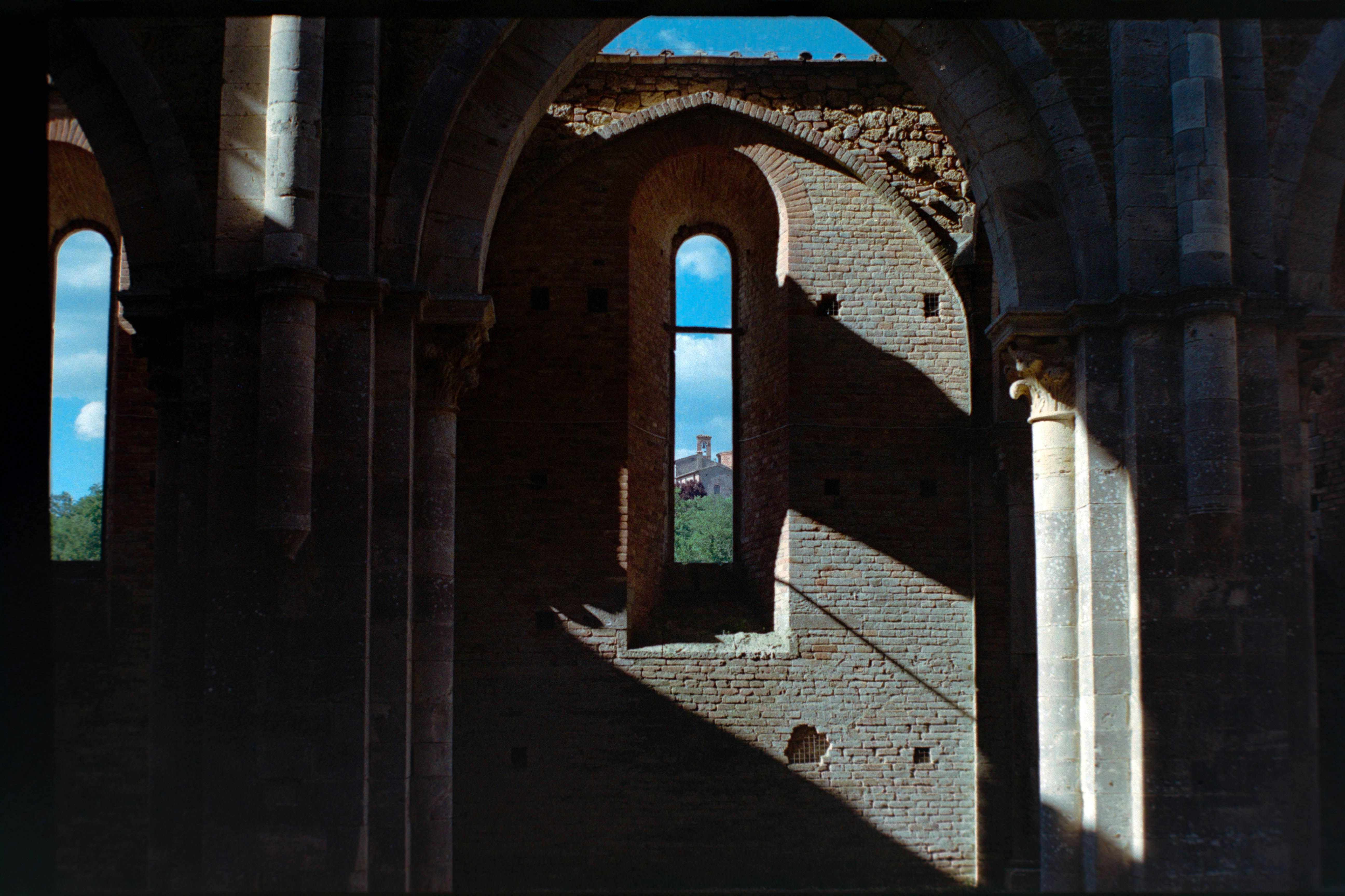 Spiragli - Marco Casirati | Ruins of an old church with arched windows and sunlight.