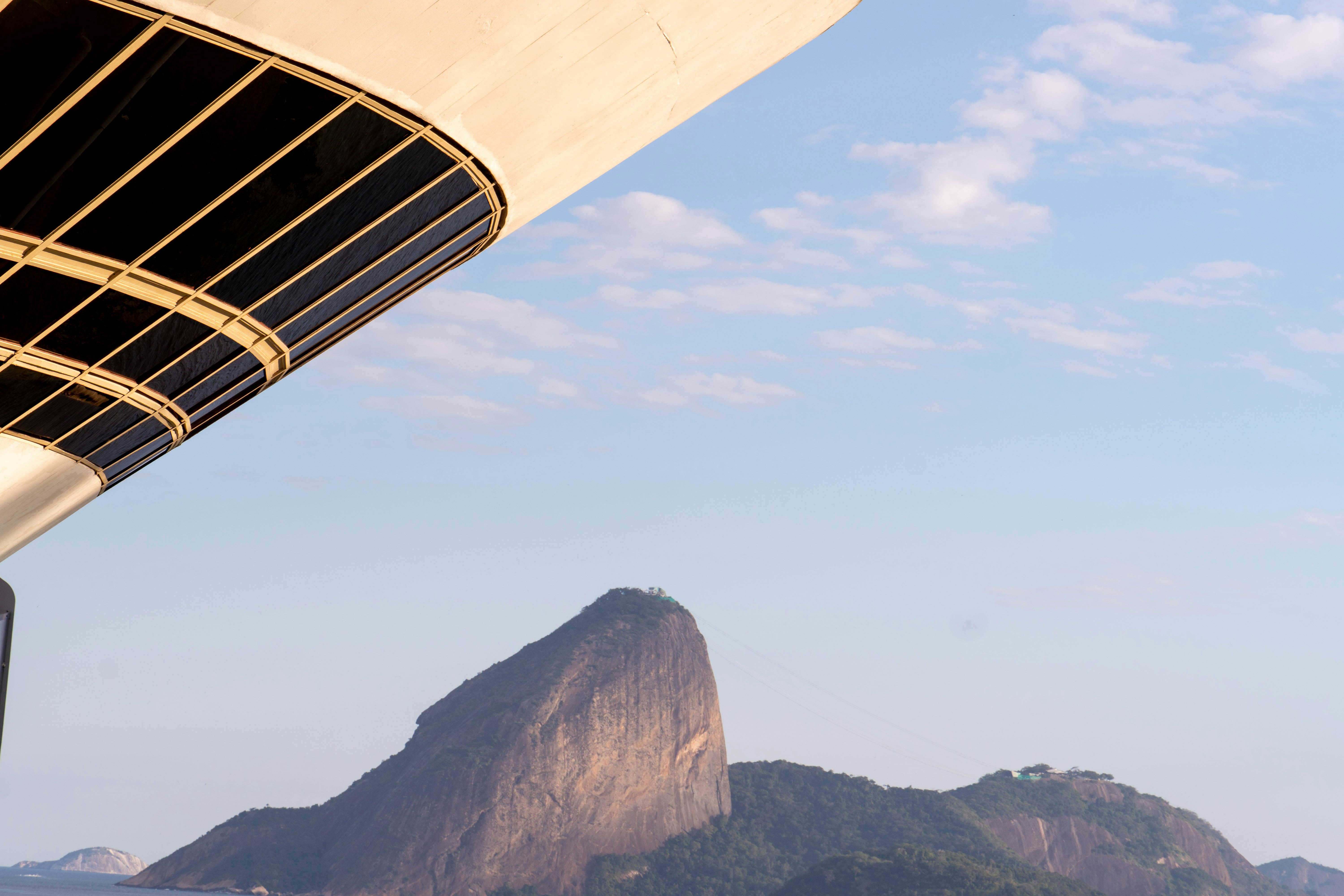Curved Roof Framing a Distant Island Peak Under Blue Sky