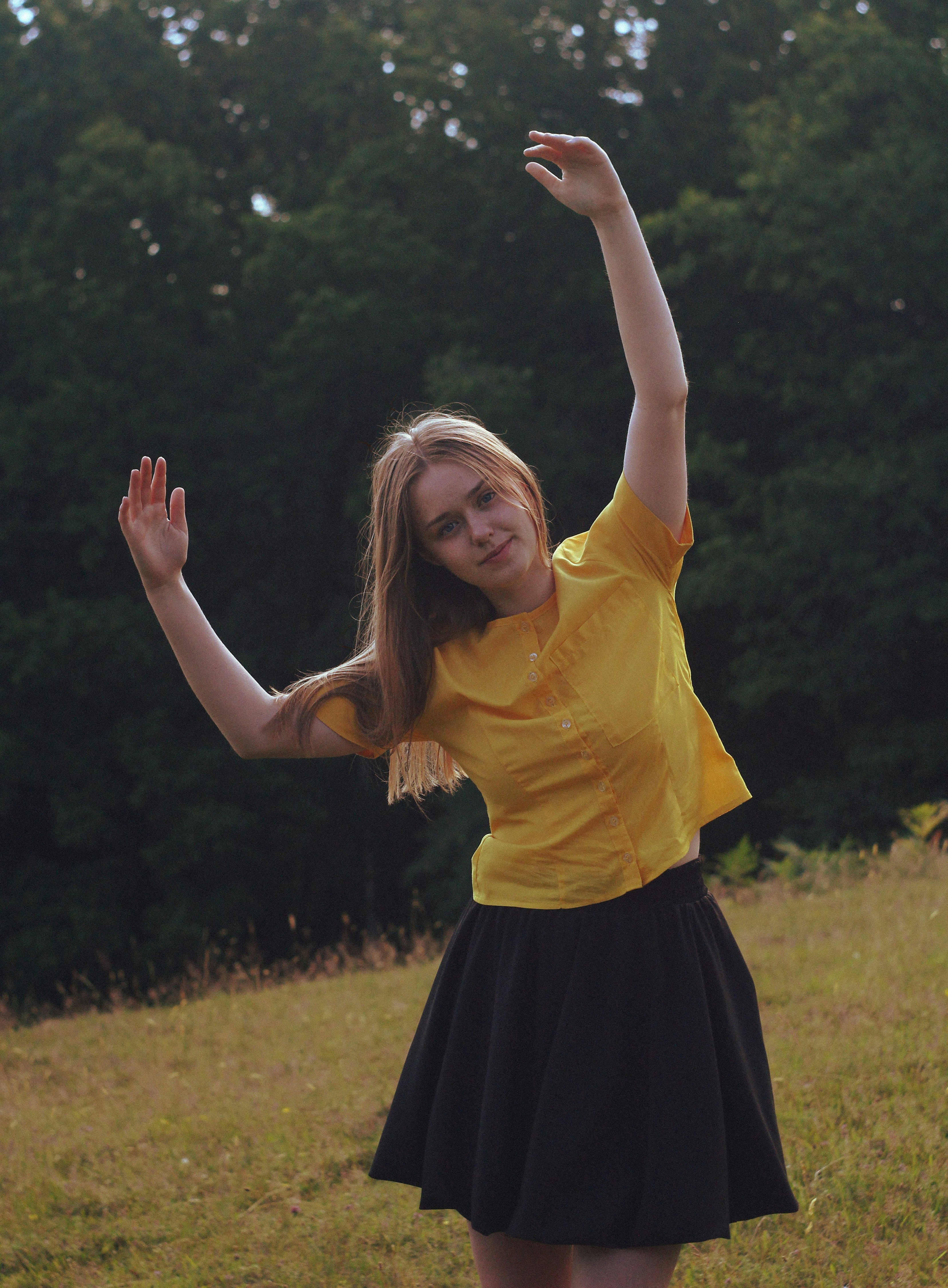Young woman with arms raised in a field