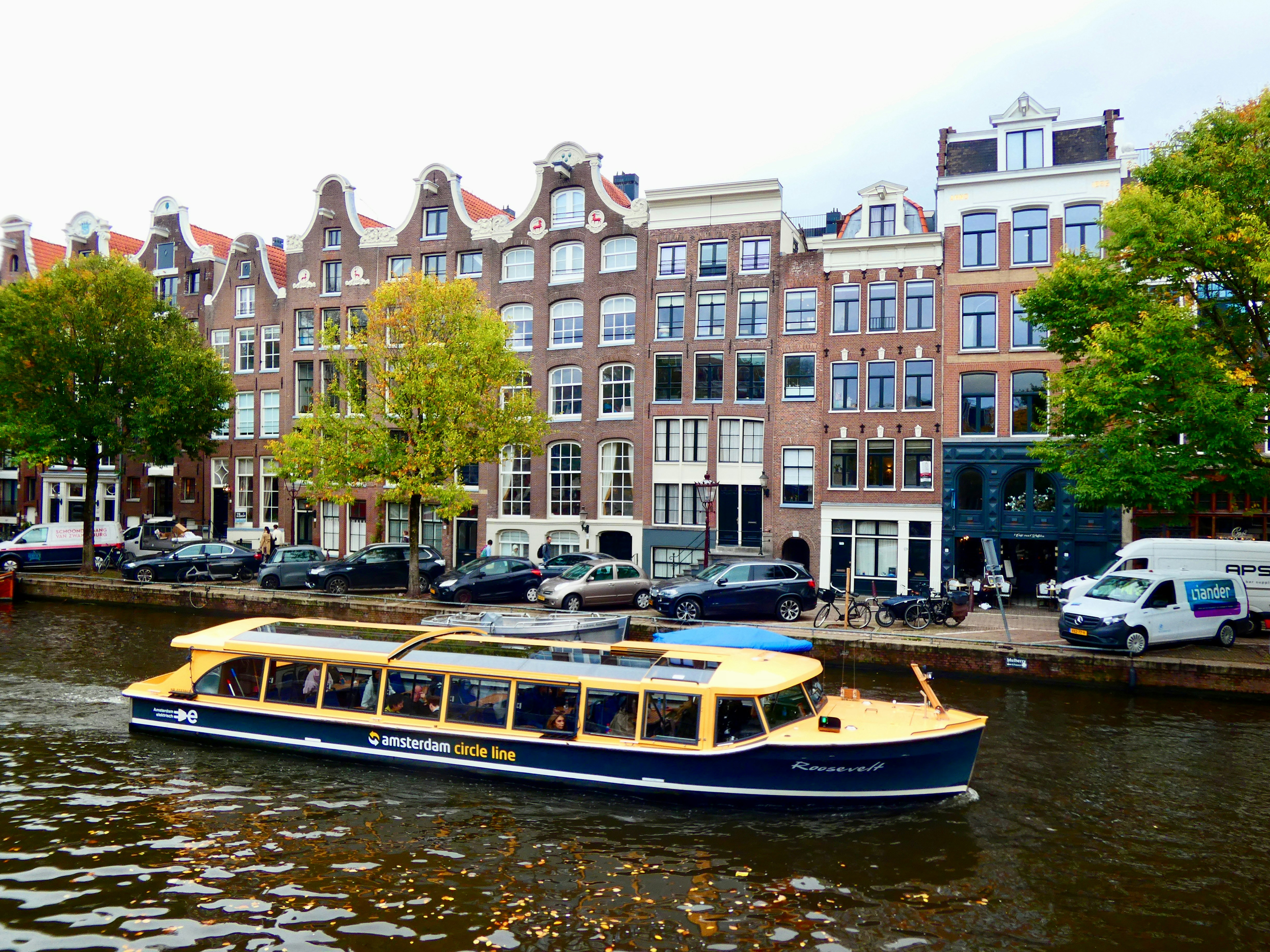 Tour boat on a canal with historic buildings.