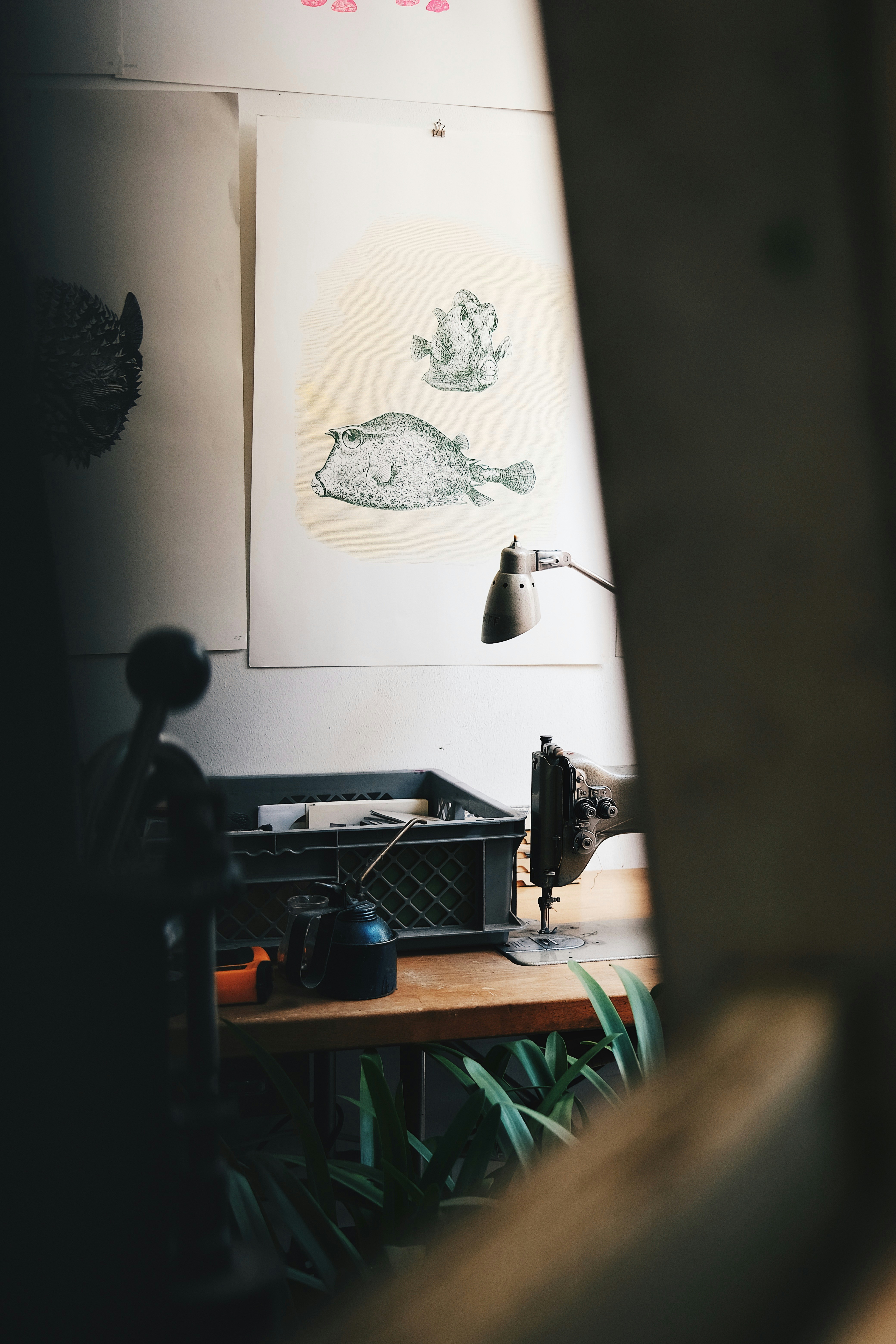 Sewing machine on a wooden desk with artwork