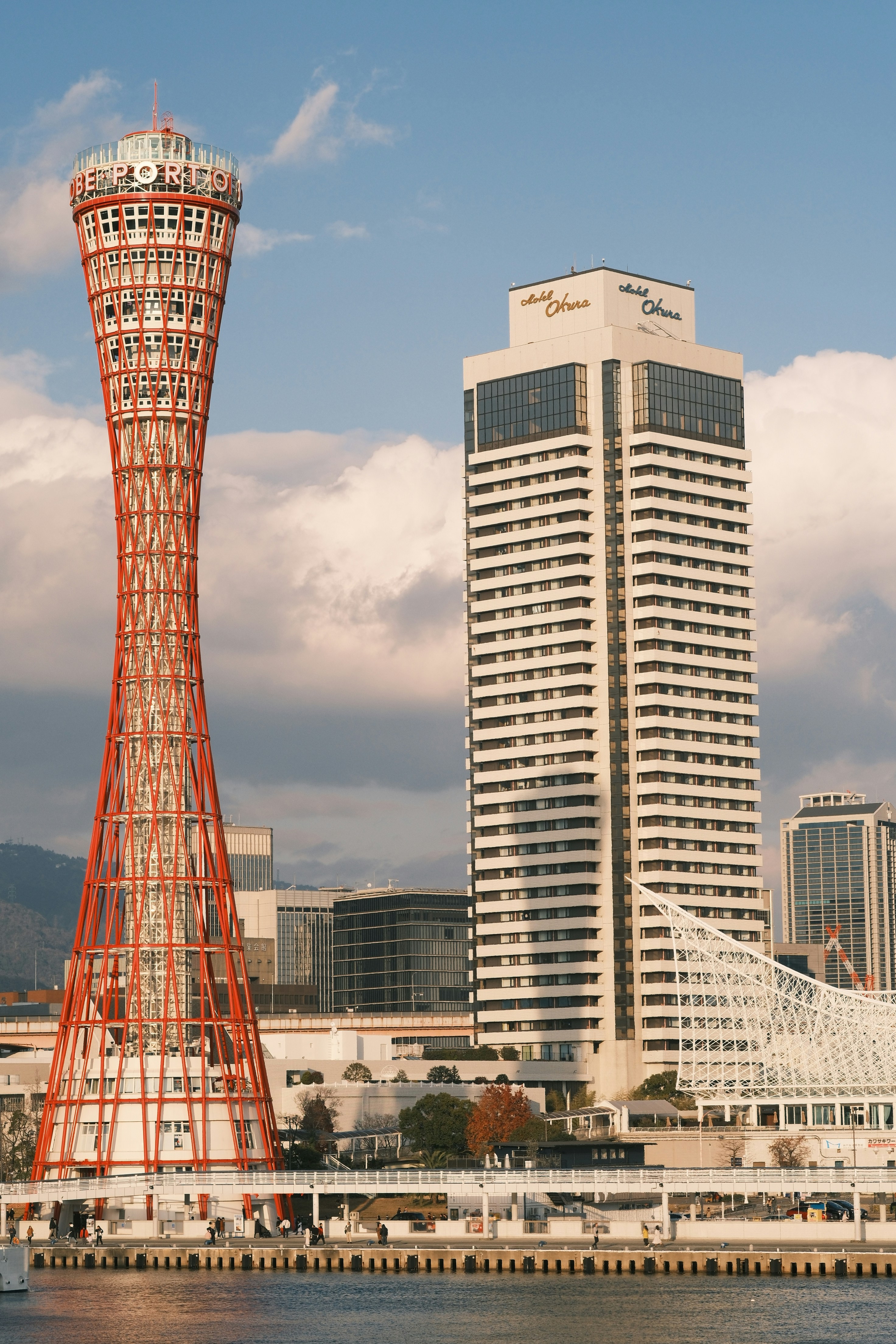 Red tower and modern buildings by the water