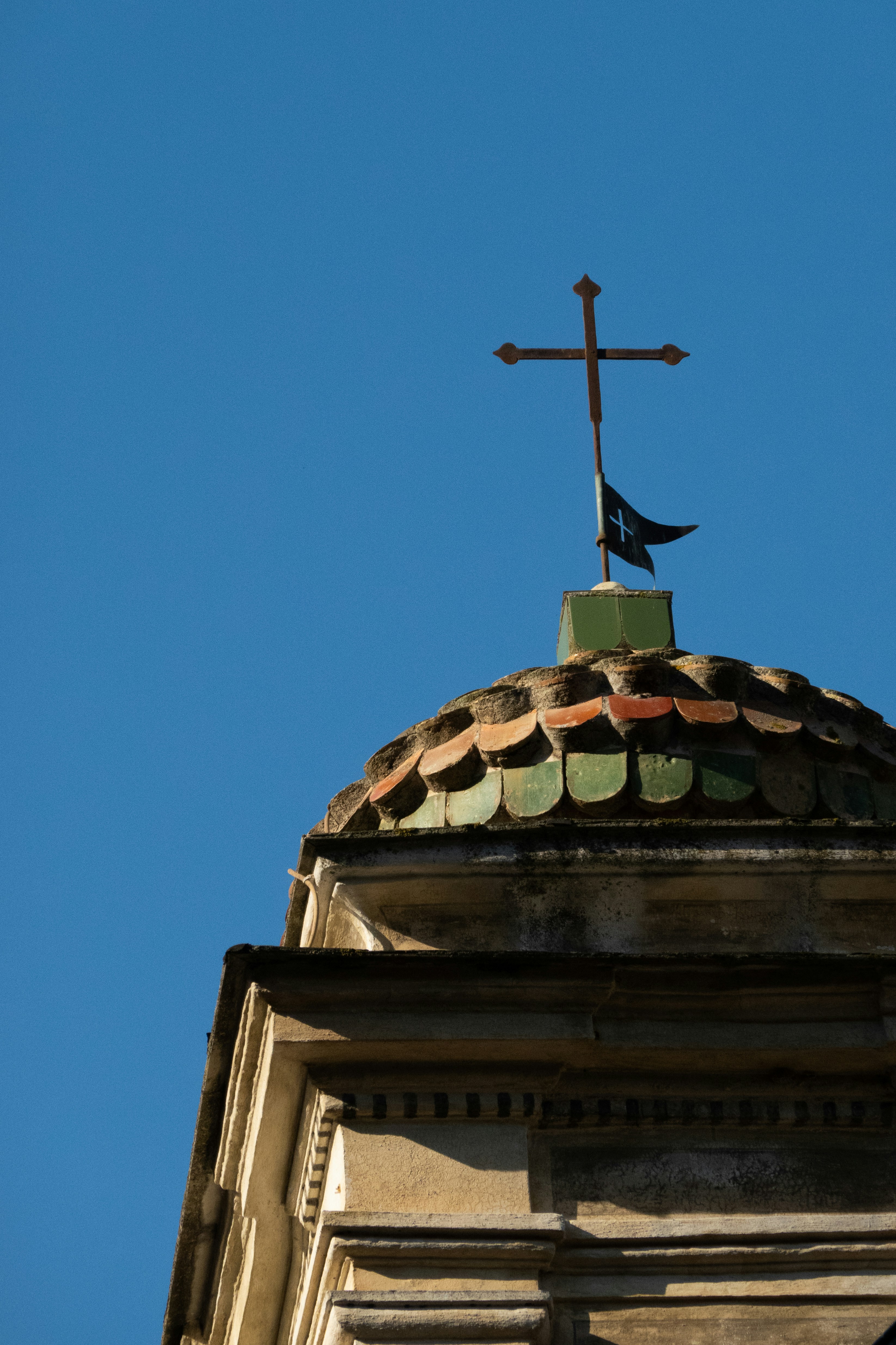 Cross and flag atop a church dome