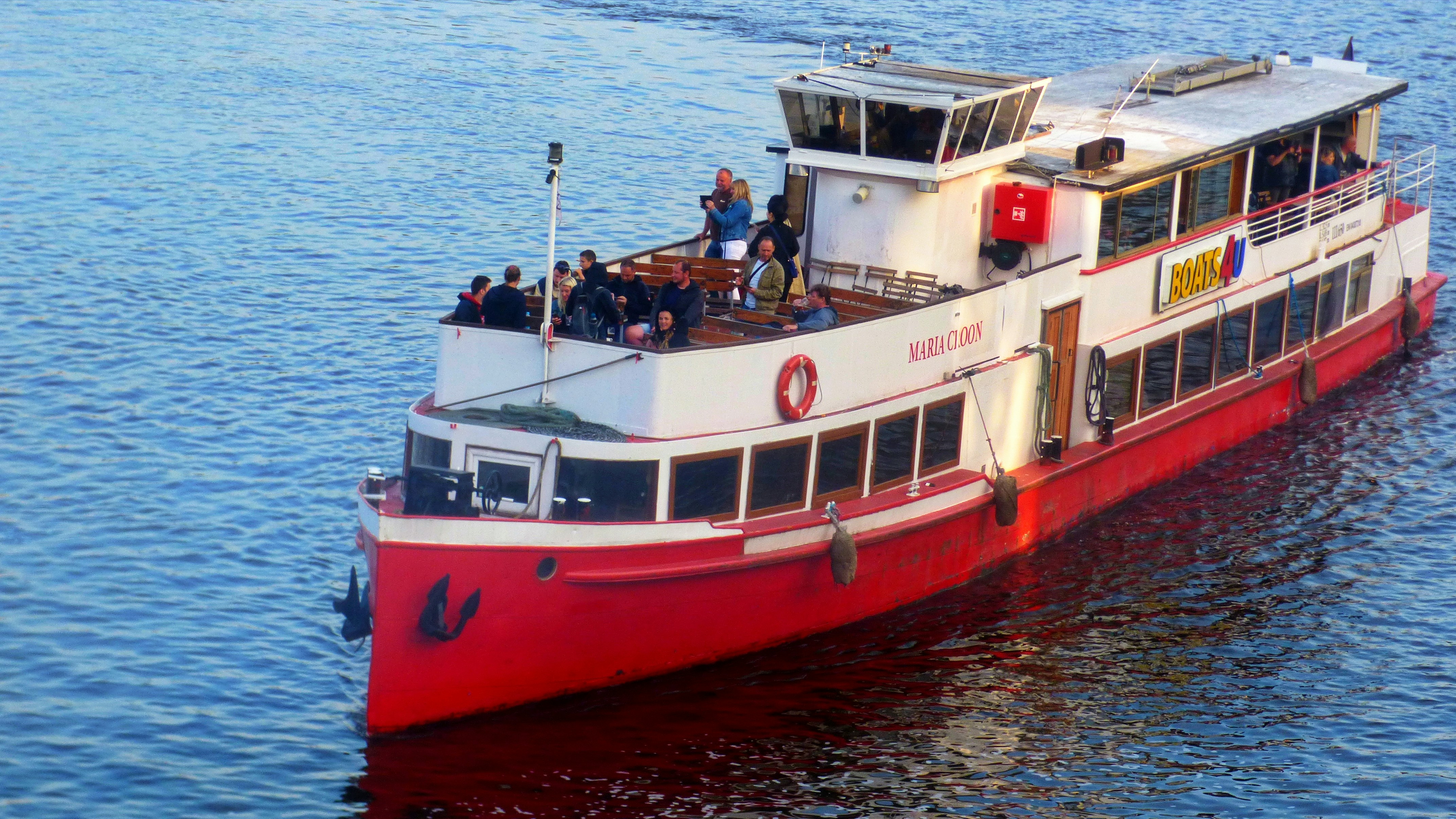 A lively riverboat filled with passengers navigating tranquil waters, showcasing the joy of scenic cruising.
