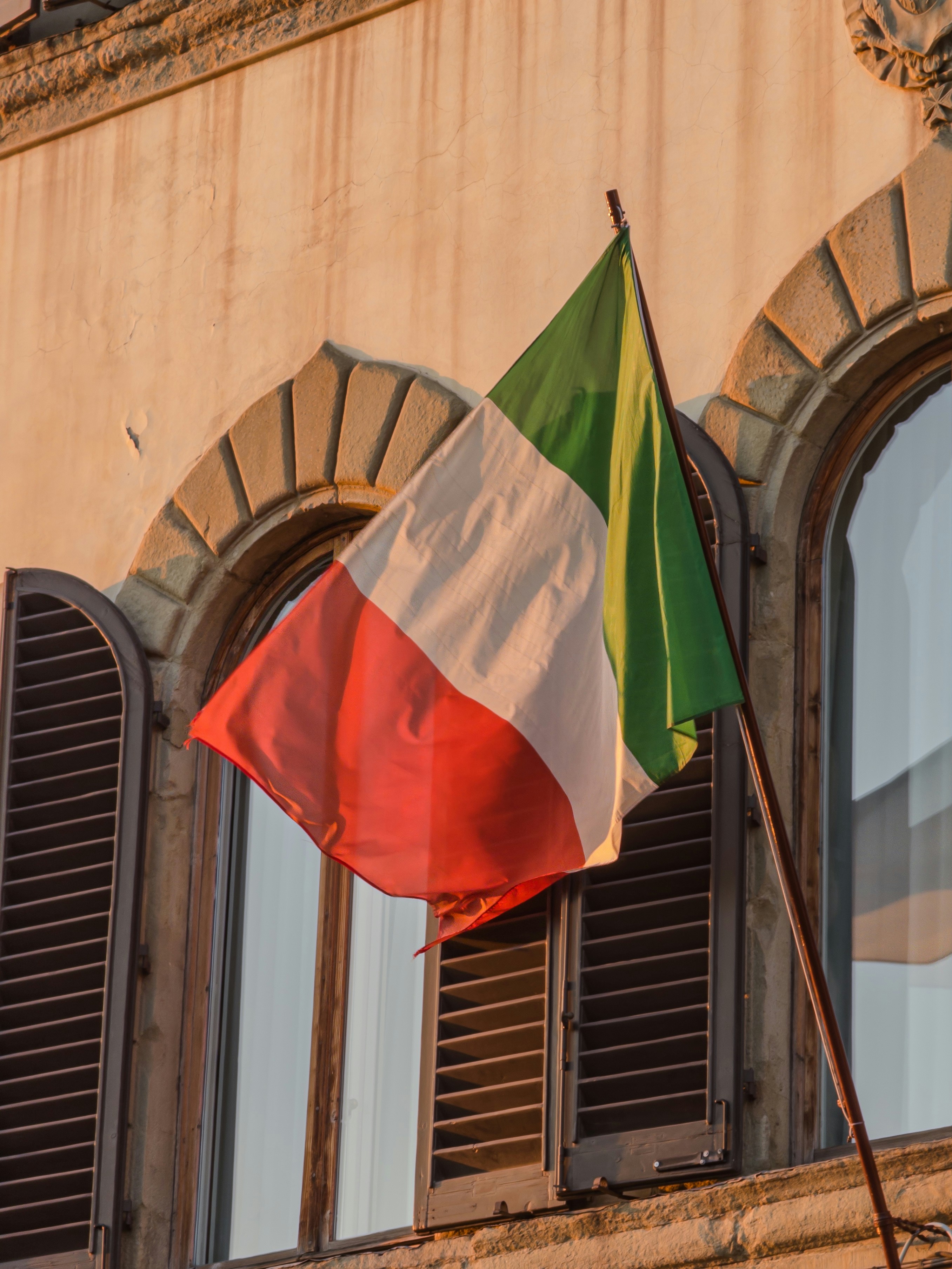 Italian flag waving on a building facade.