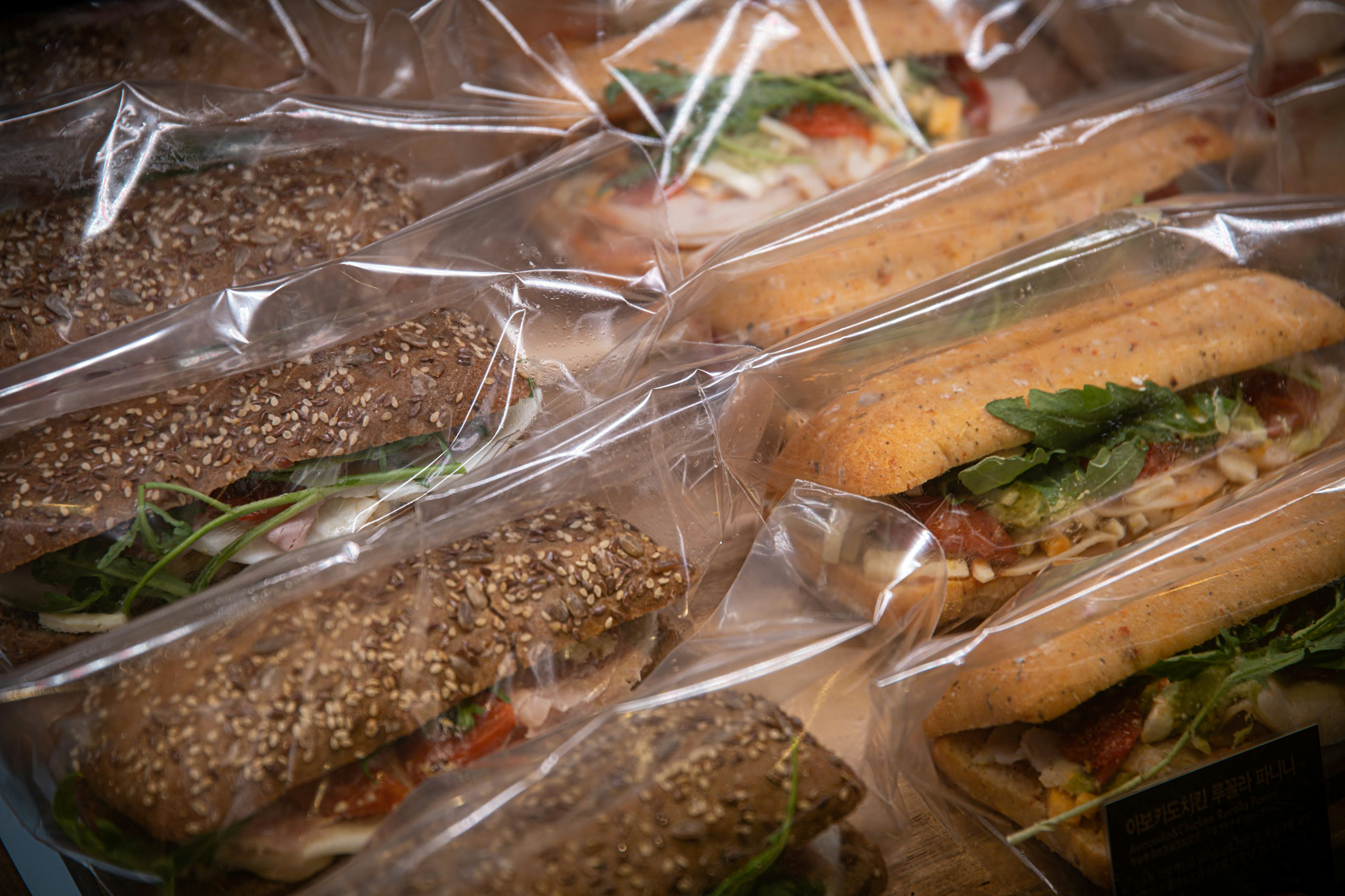 Freshly made sandwiches wrapped in plastic wrap.
