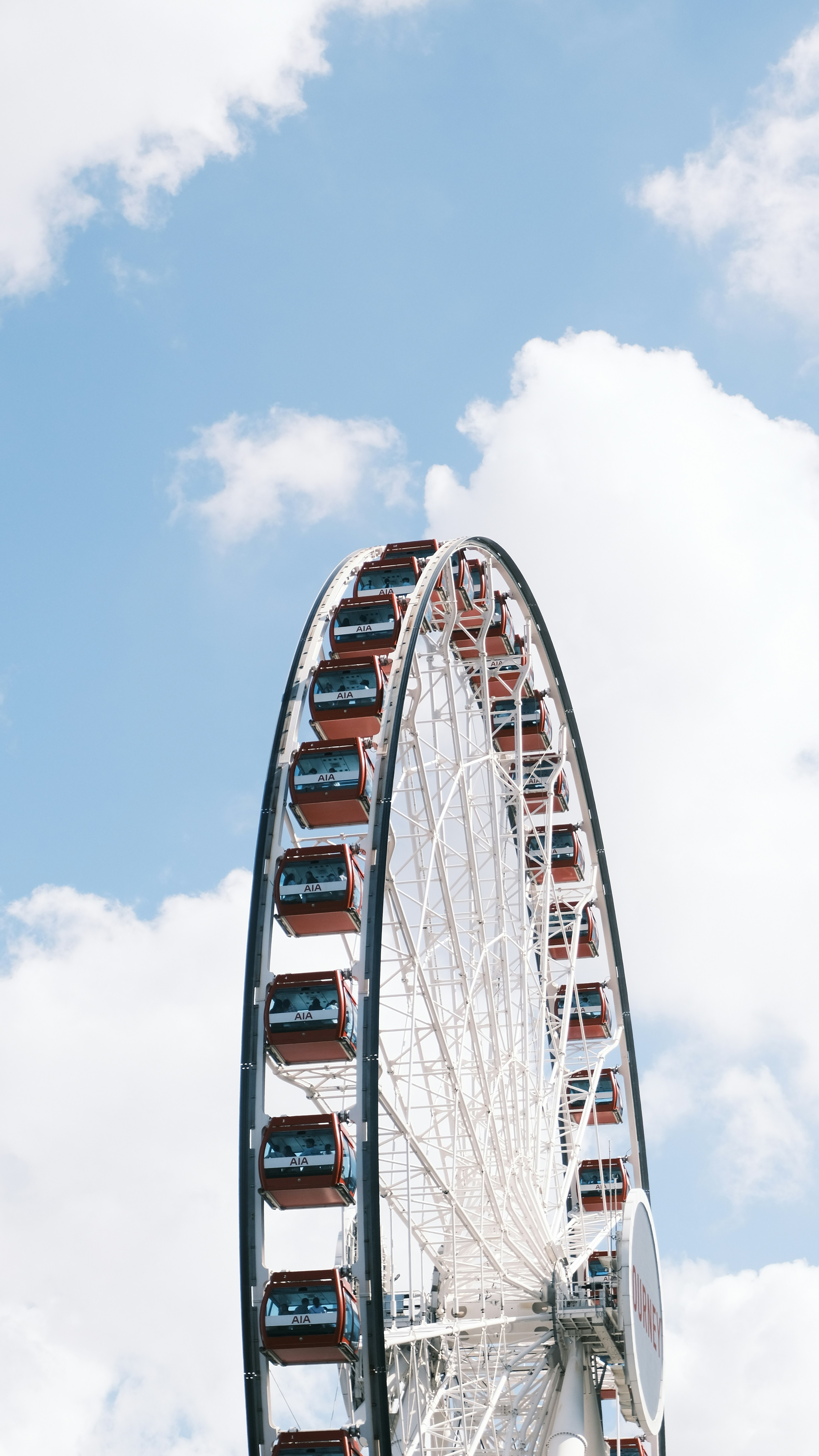 A ferris wheel against a blue sky with clouds