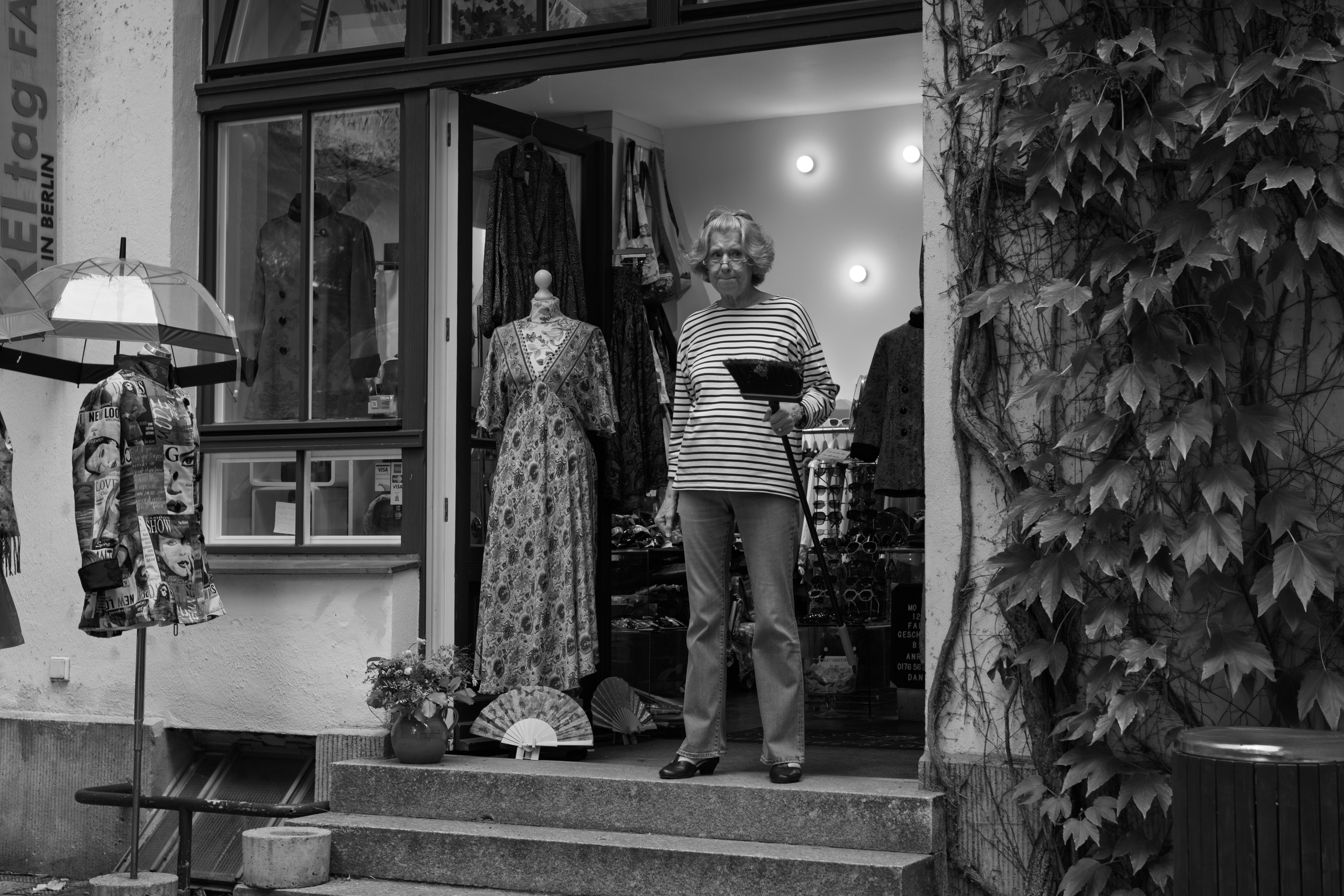 Woman standing in a vintage clothing store entrance.