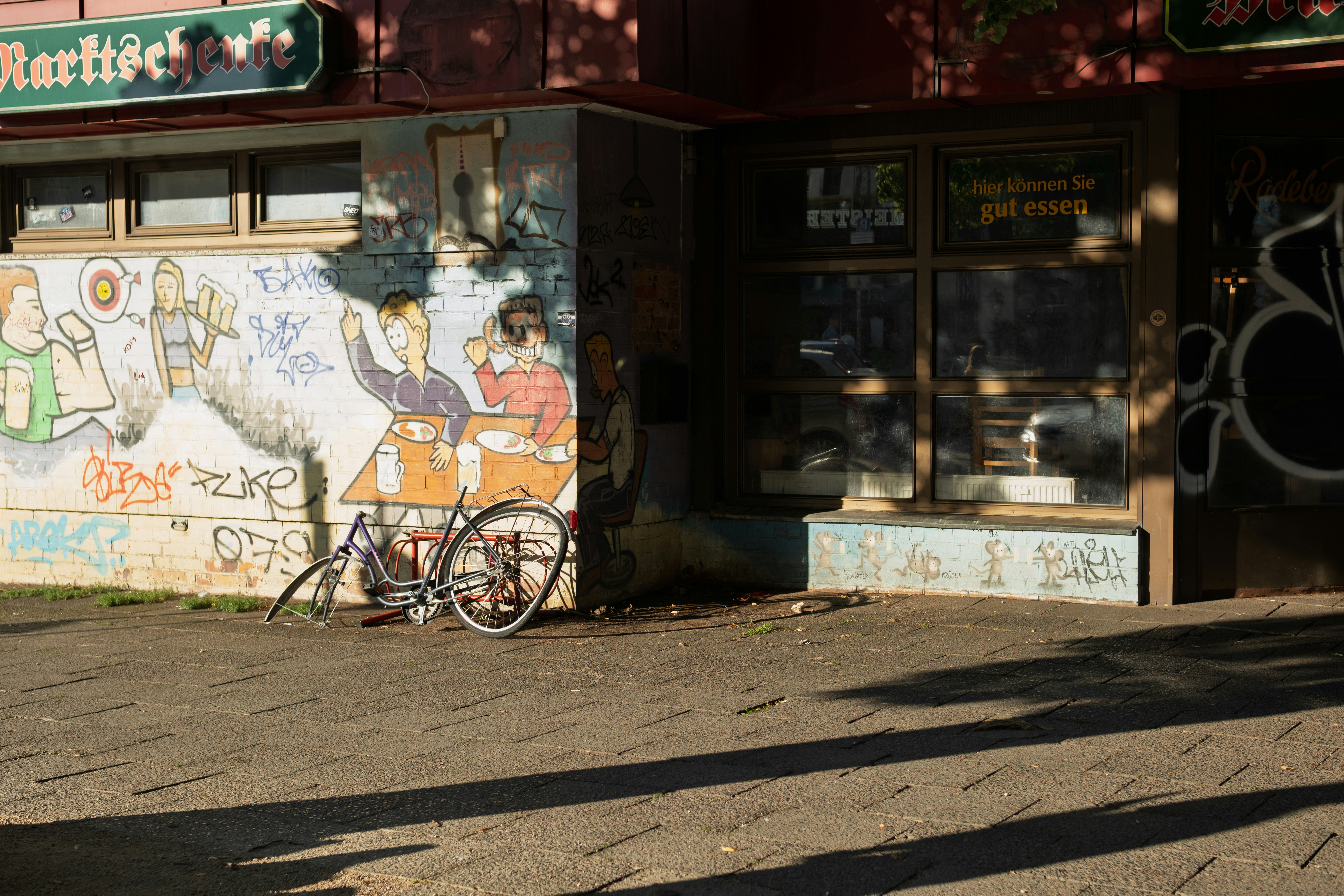A bicycle leans against a graffiti-covered wall.