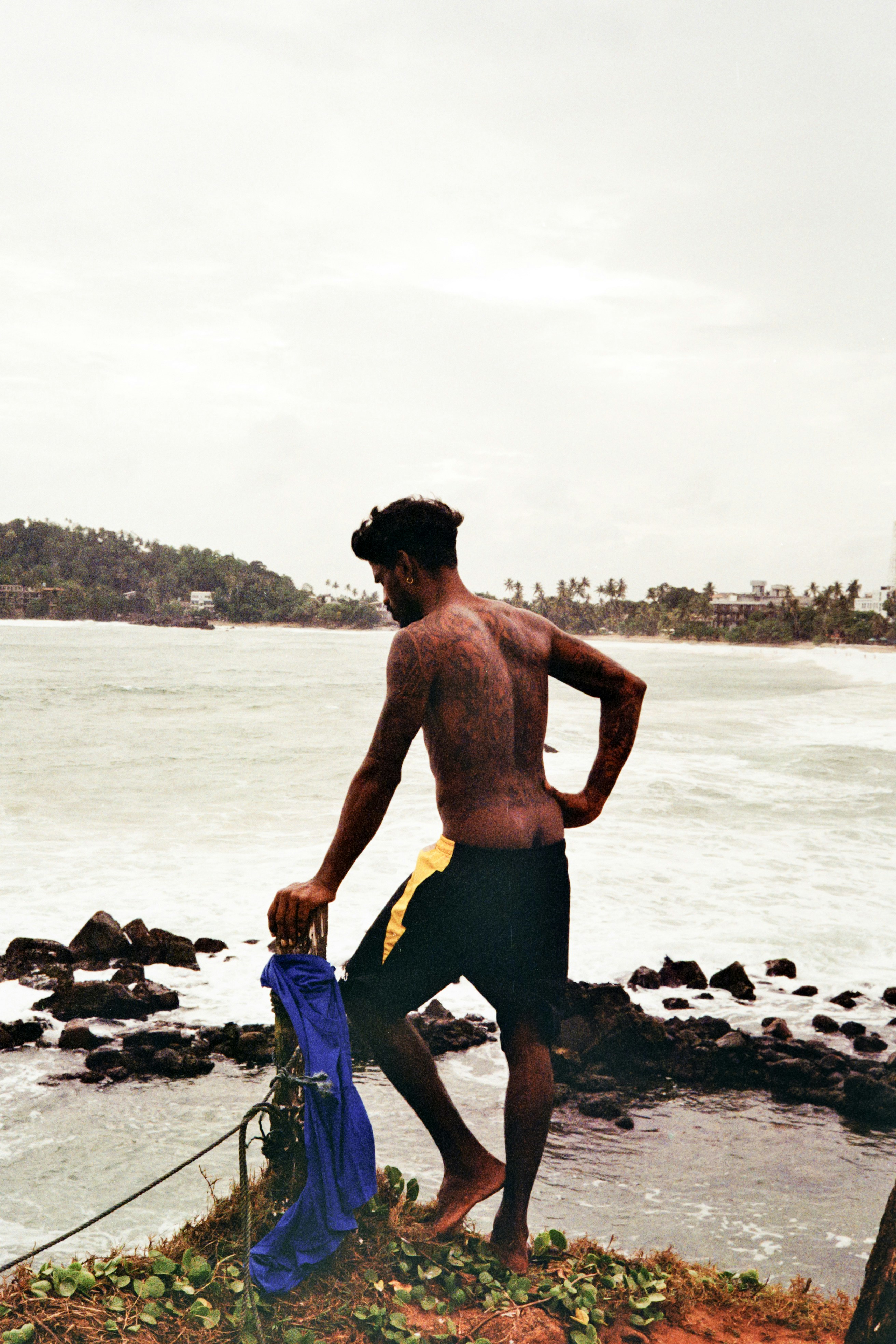 Kodak Gold 200 🎞️ | Man standing on rocky shore overlooking ocean