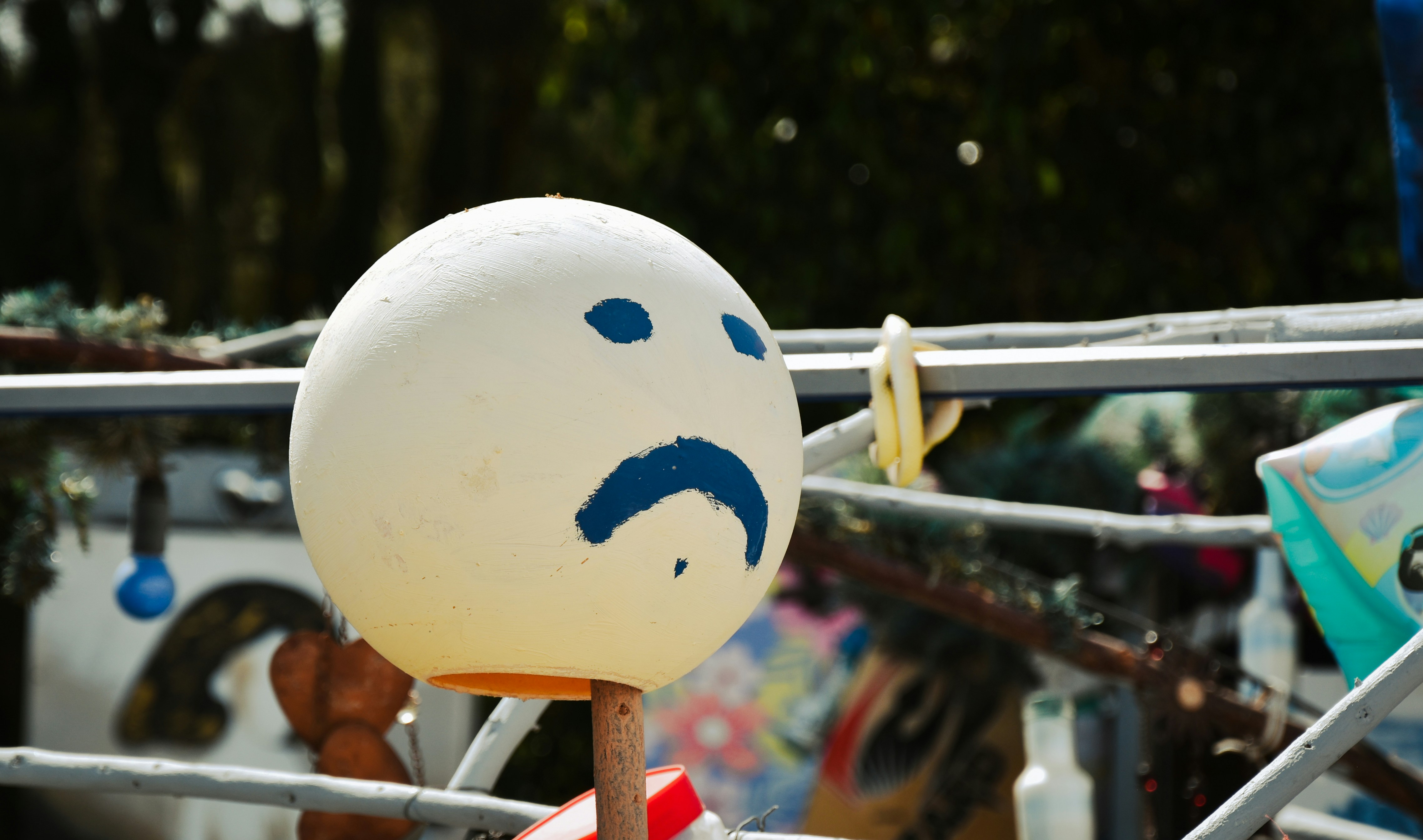 In Lanzarote, this buoy — which was collected while removing trash from the beach and coastline — has been turned into an art exhibition. | A white sphere with a sad face painted on it.