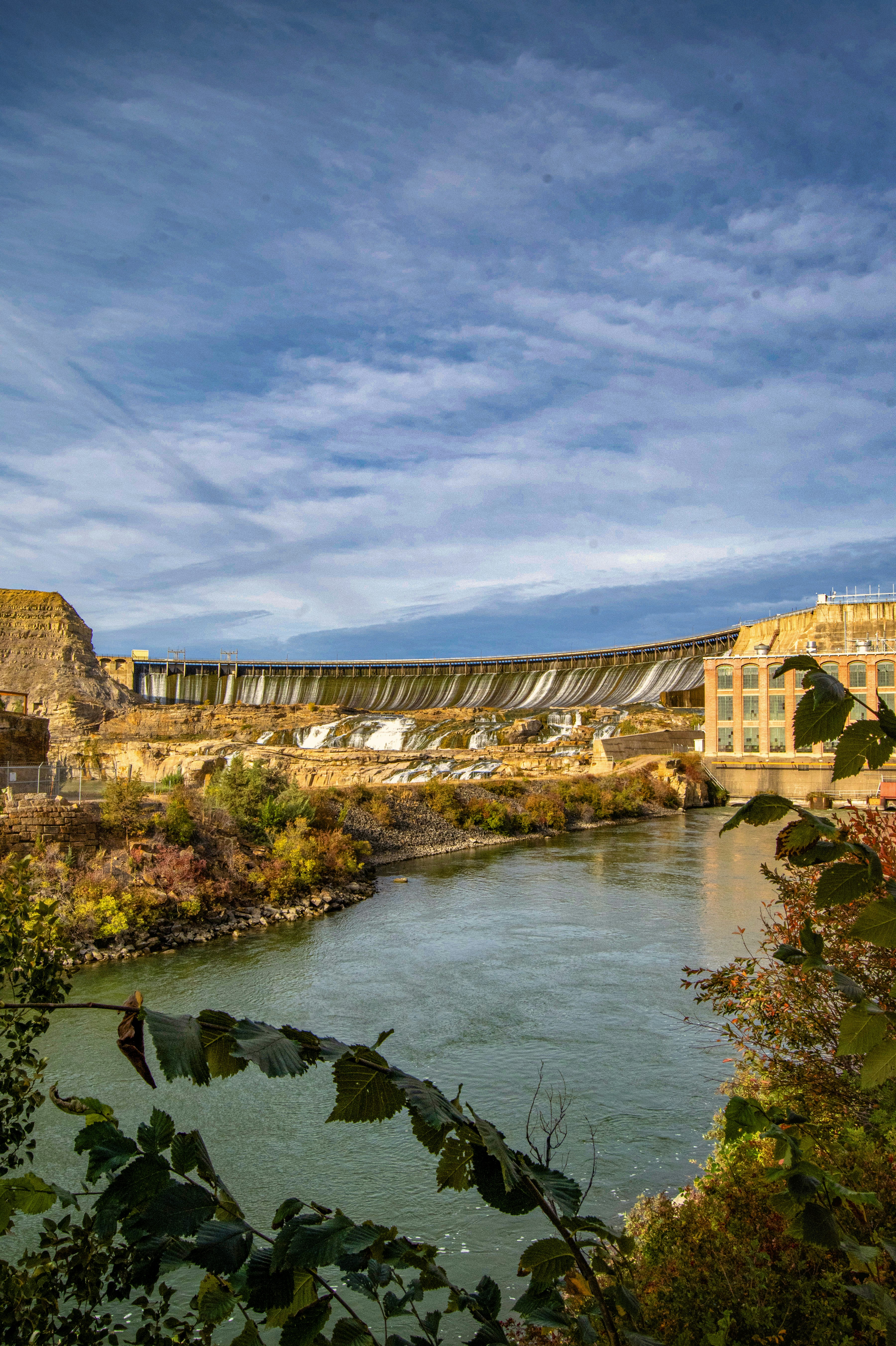 A wide dam with water flowing over it.