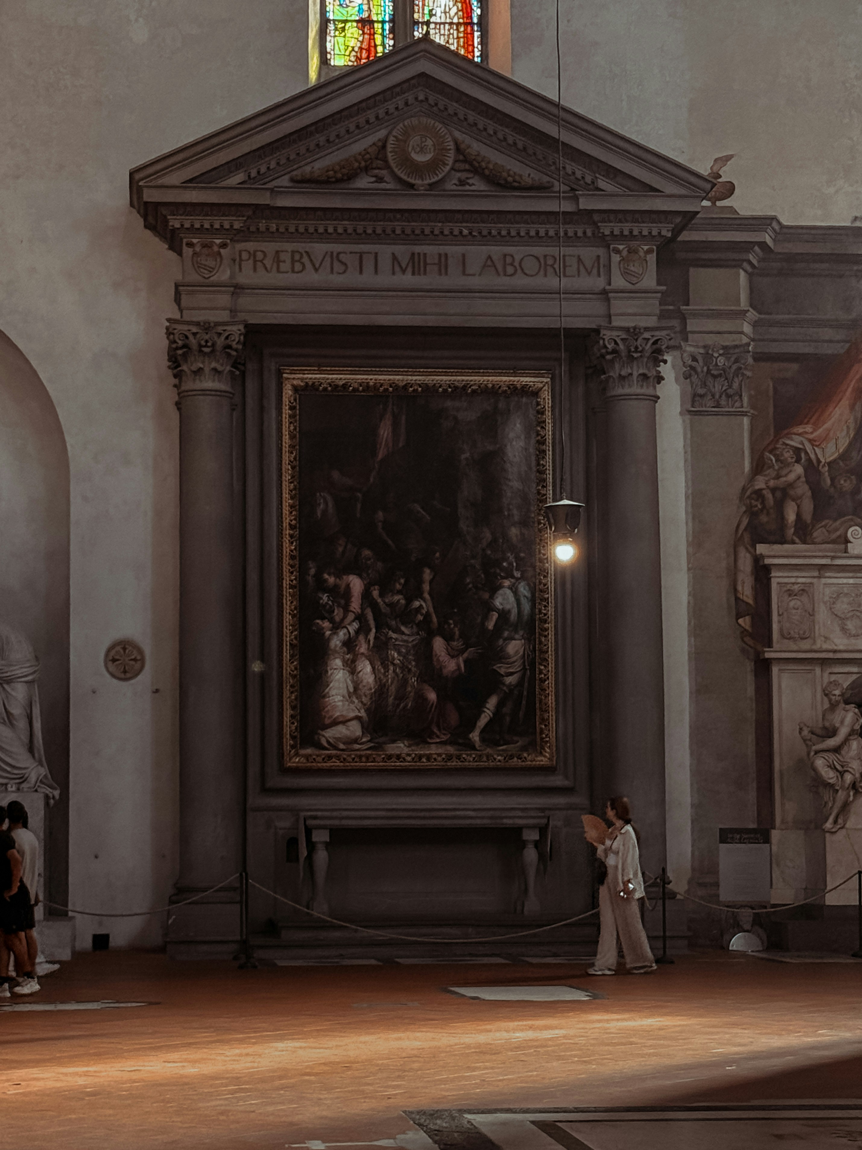 A person admires a large painting in a grand hall.