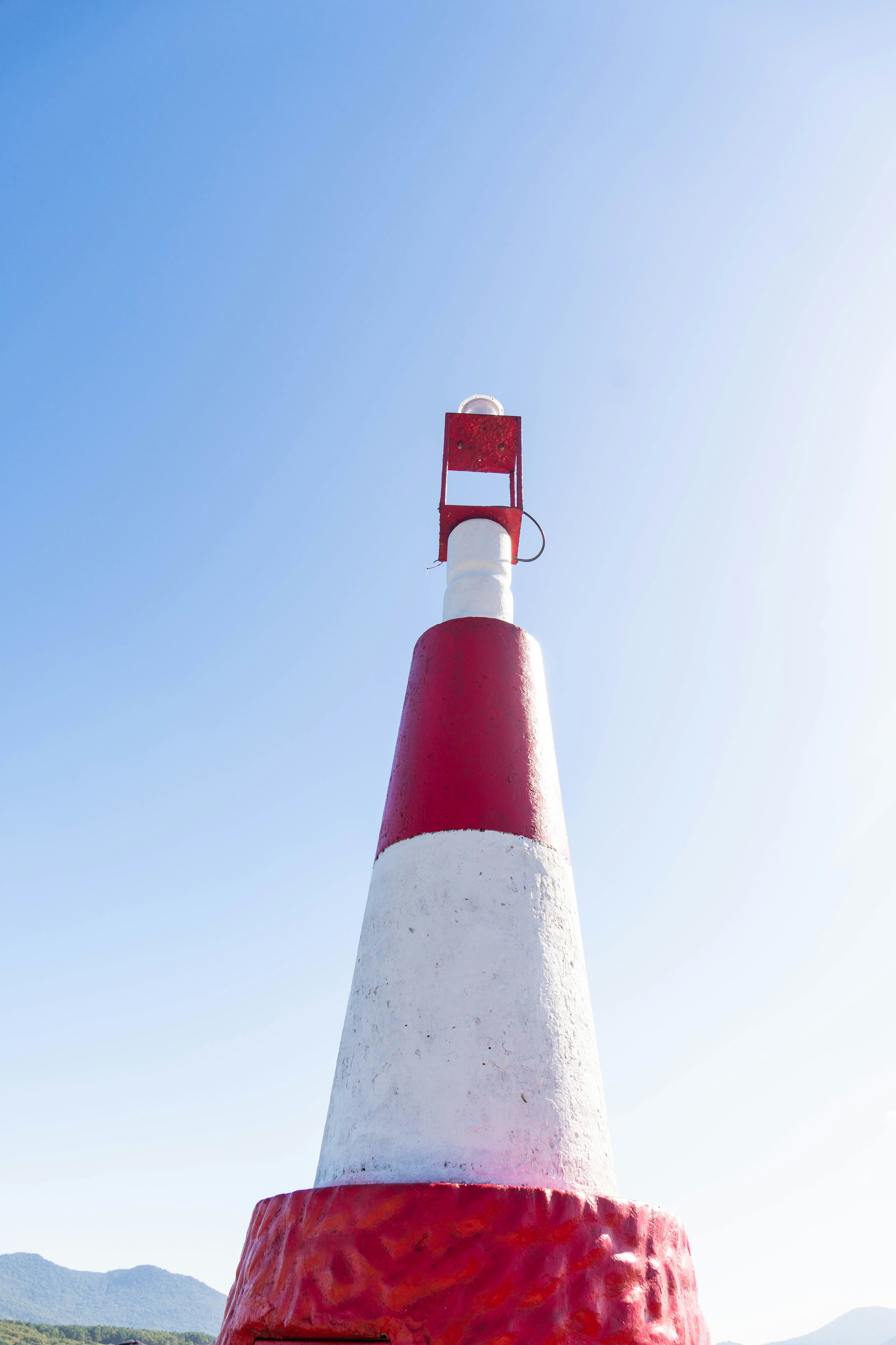 Red and white buoy against a clear blue sky