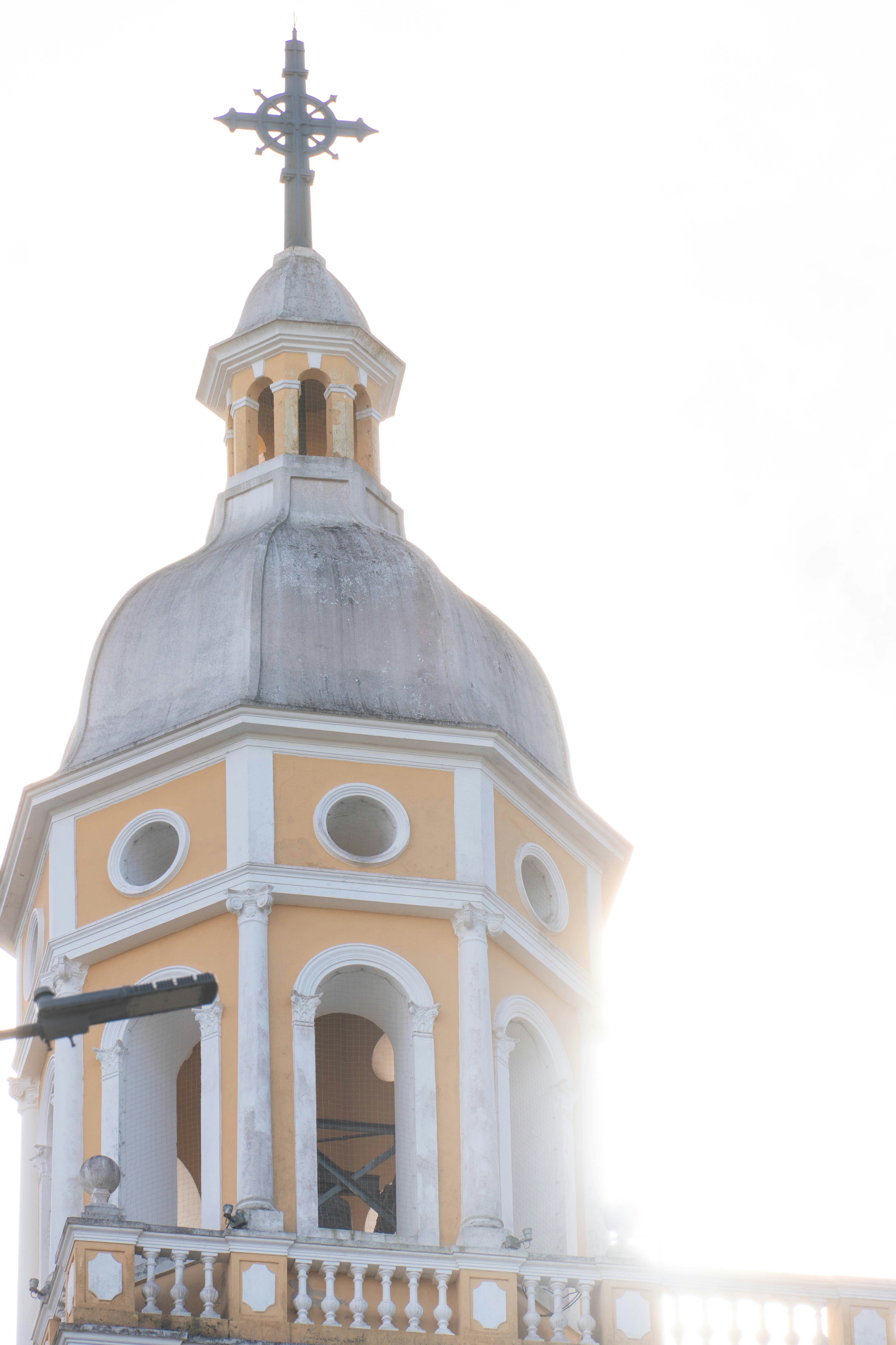 Yellow Baroque Bell Tower Reaching Into a Blinding Sky