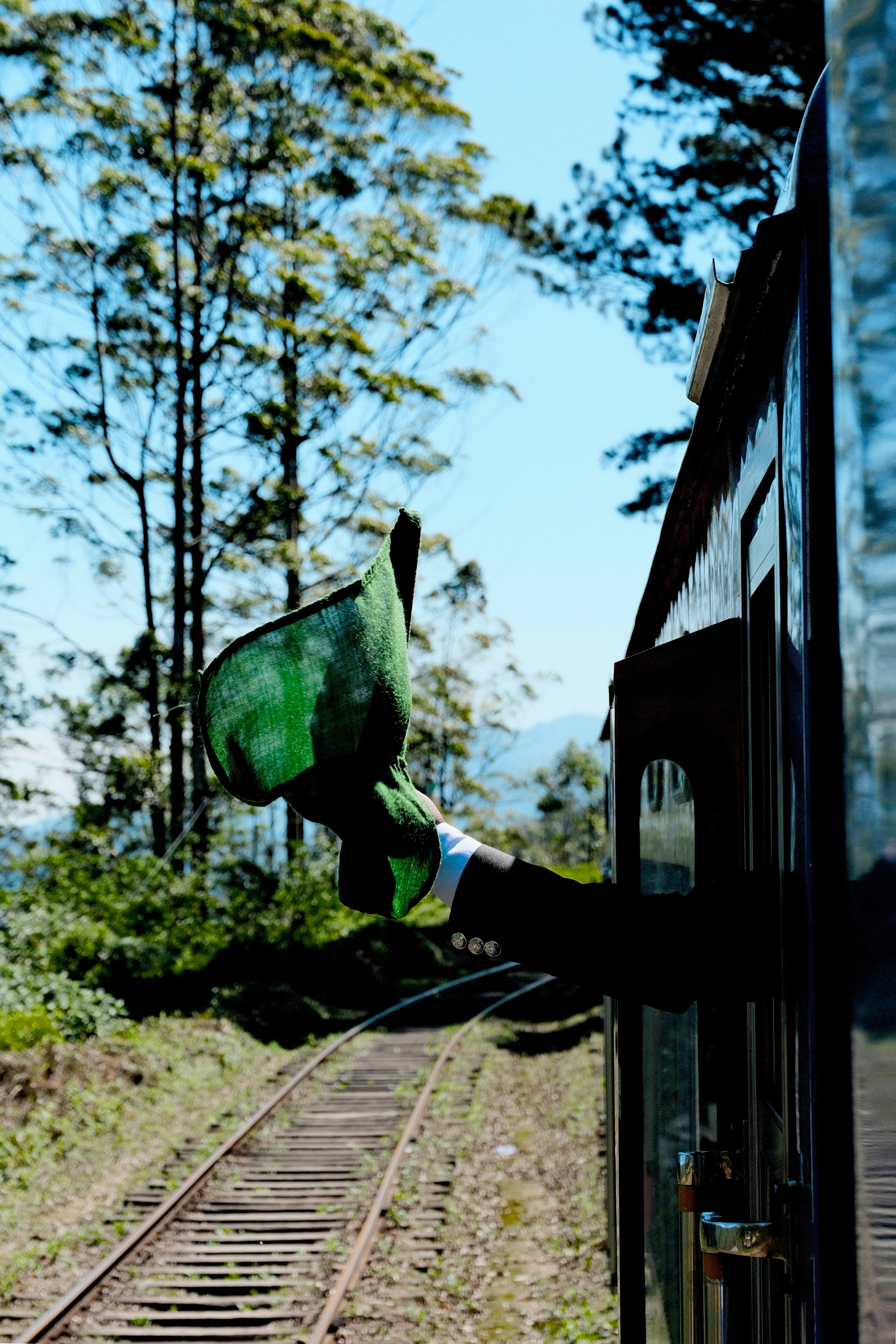 Green cloth waving from a moving train window