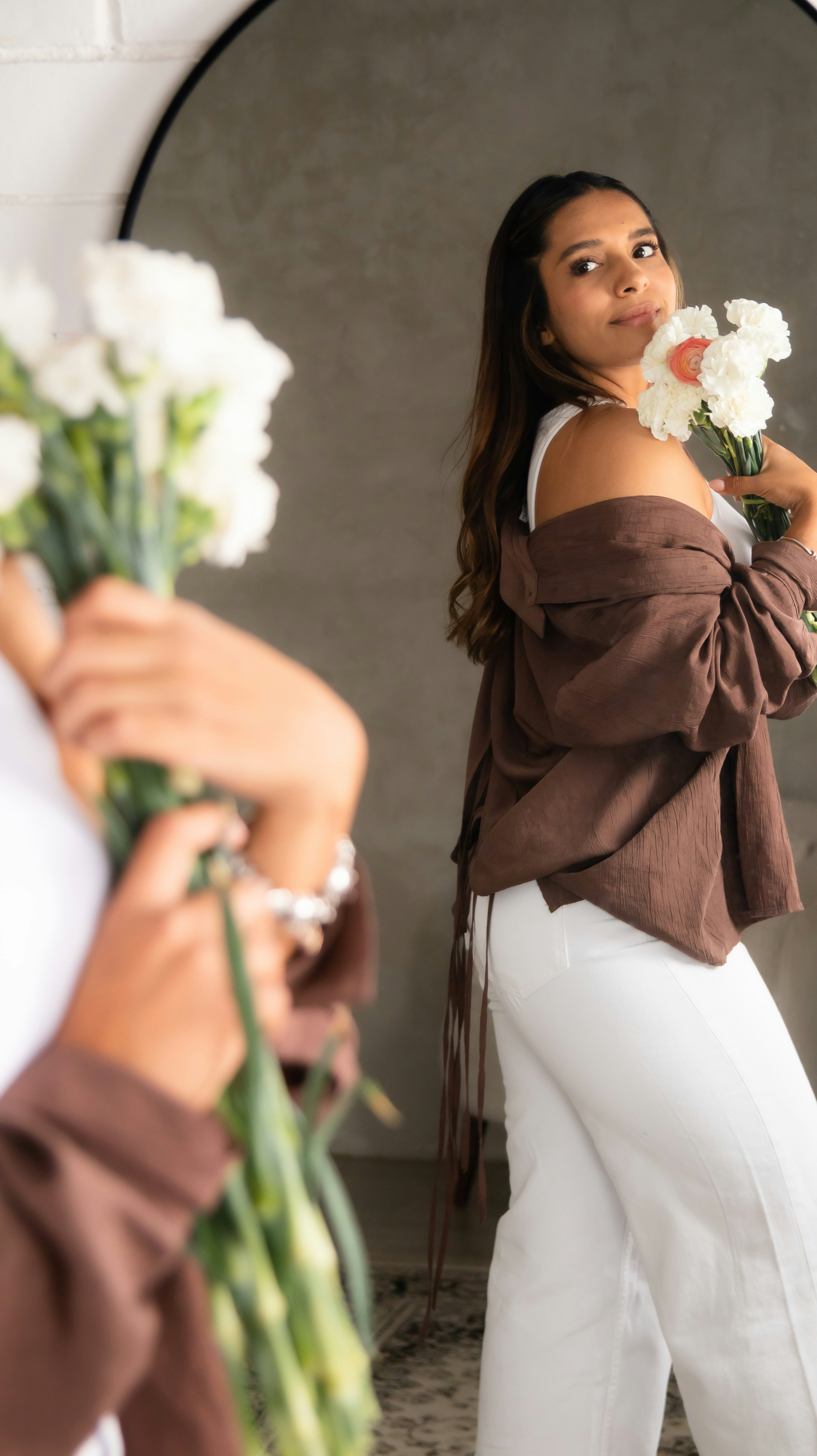 Woman holding flowers in front of a mirror