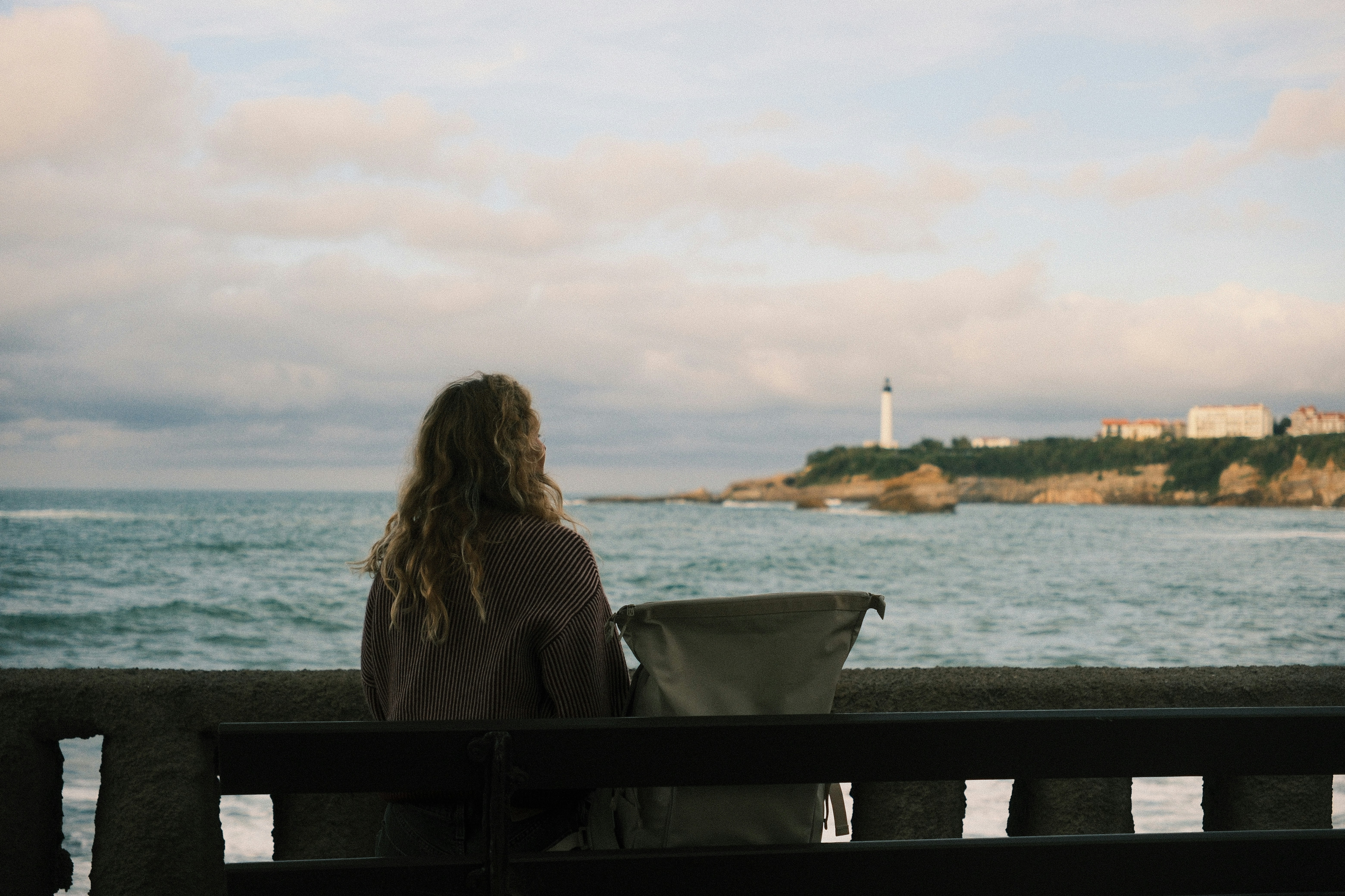 Benchside Reverie: A Quiet Moment Facing the Distant Lighthouse