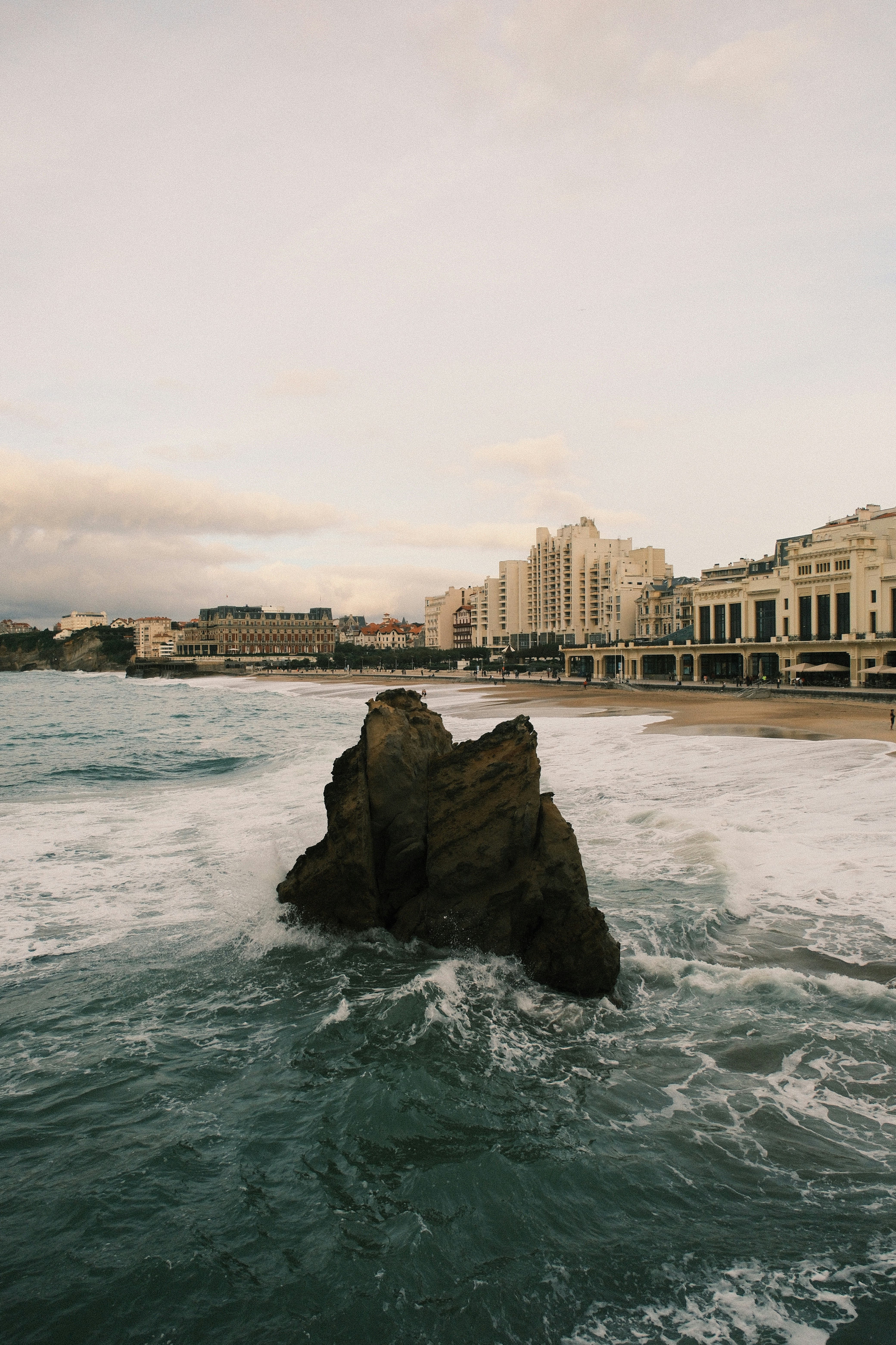 Seaside Serenity: A Rocky Outcrop Amidst Urban Waves