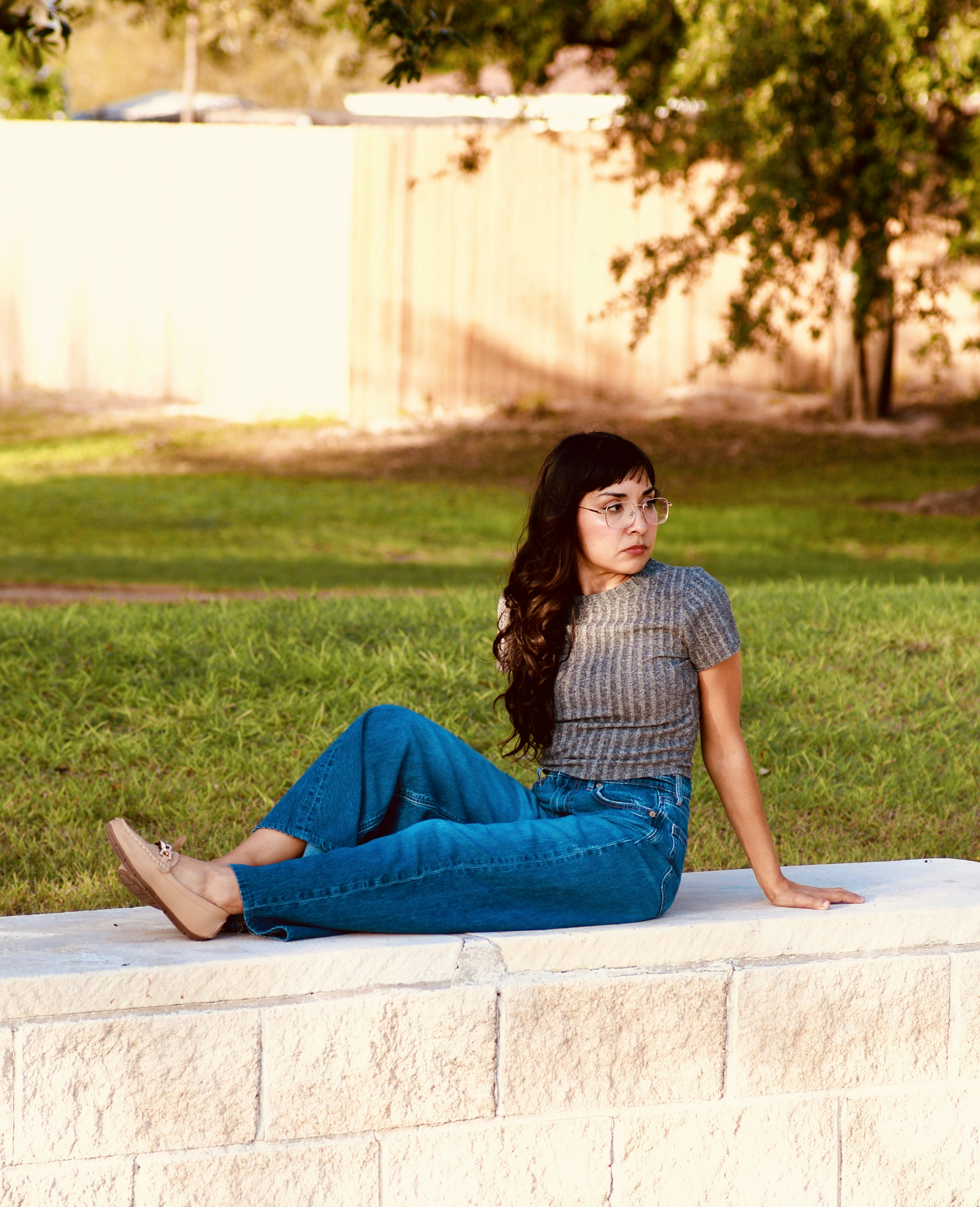 Woman sitting on a stone wall outdoors