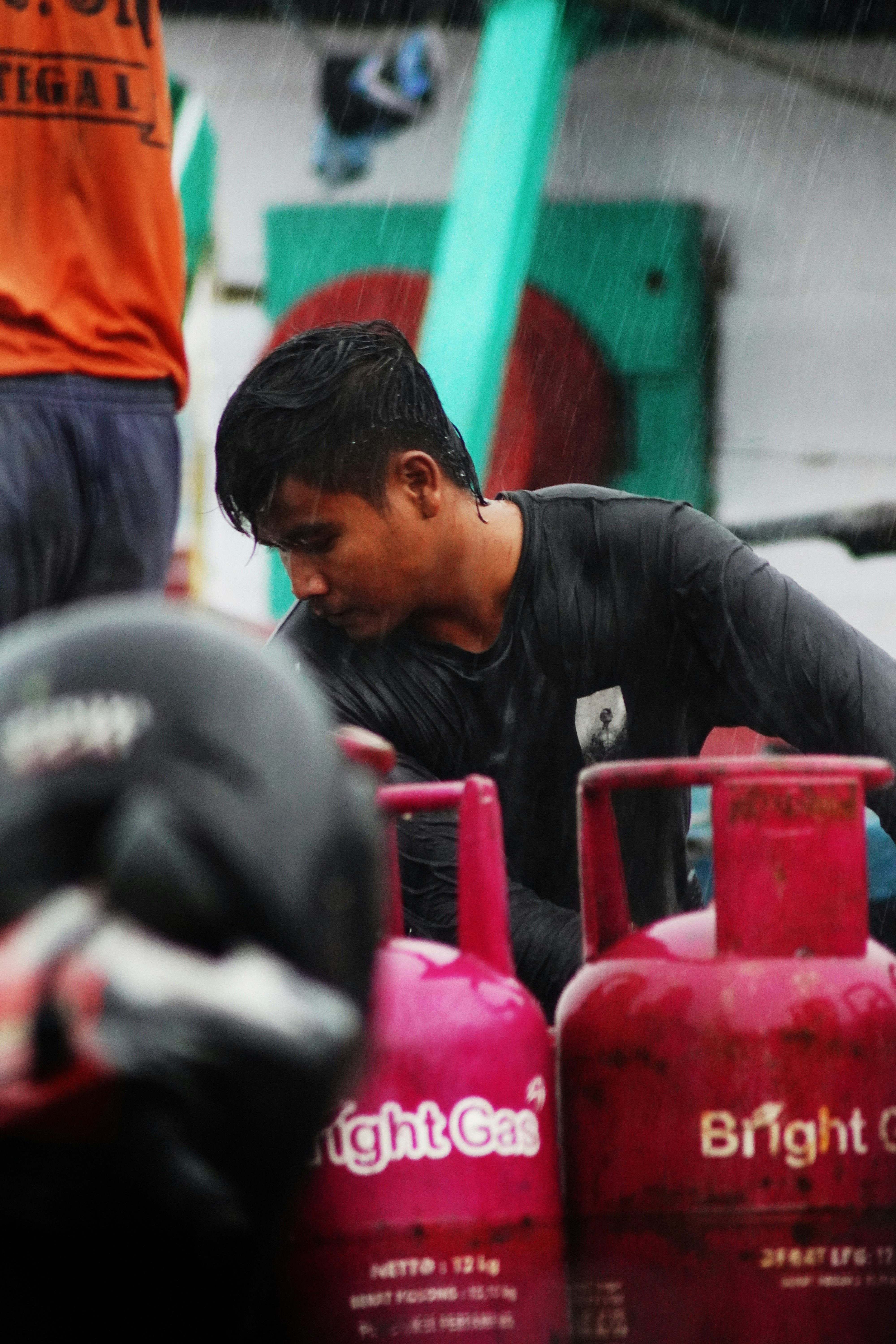 Tetap semangat bekerja walau diguyur hujan | Man working with gas cylinders in the rain