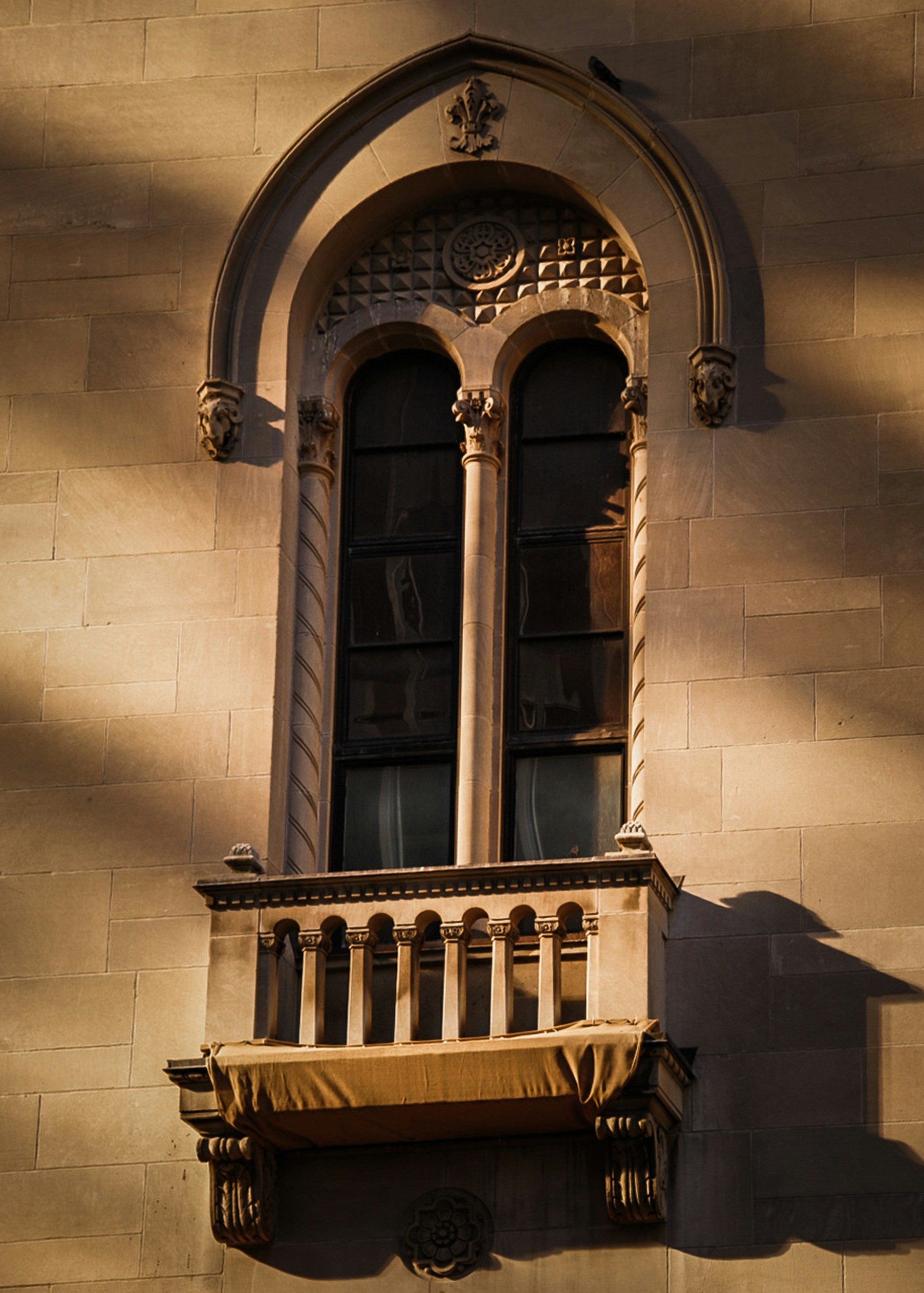 Ornate gothic window with a small balcony.
