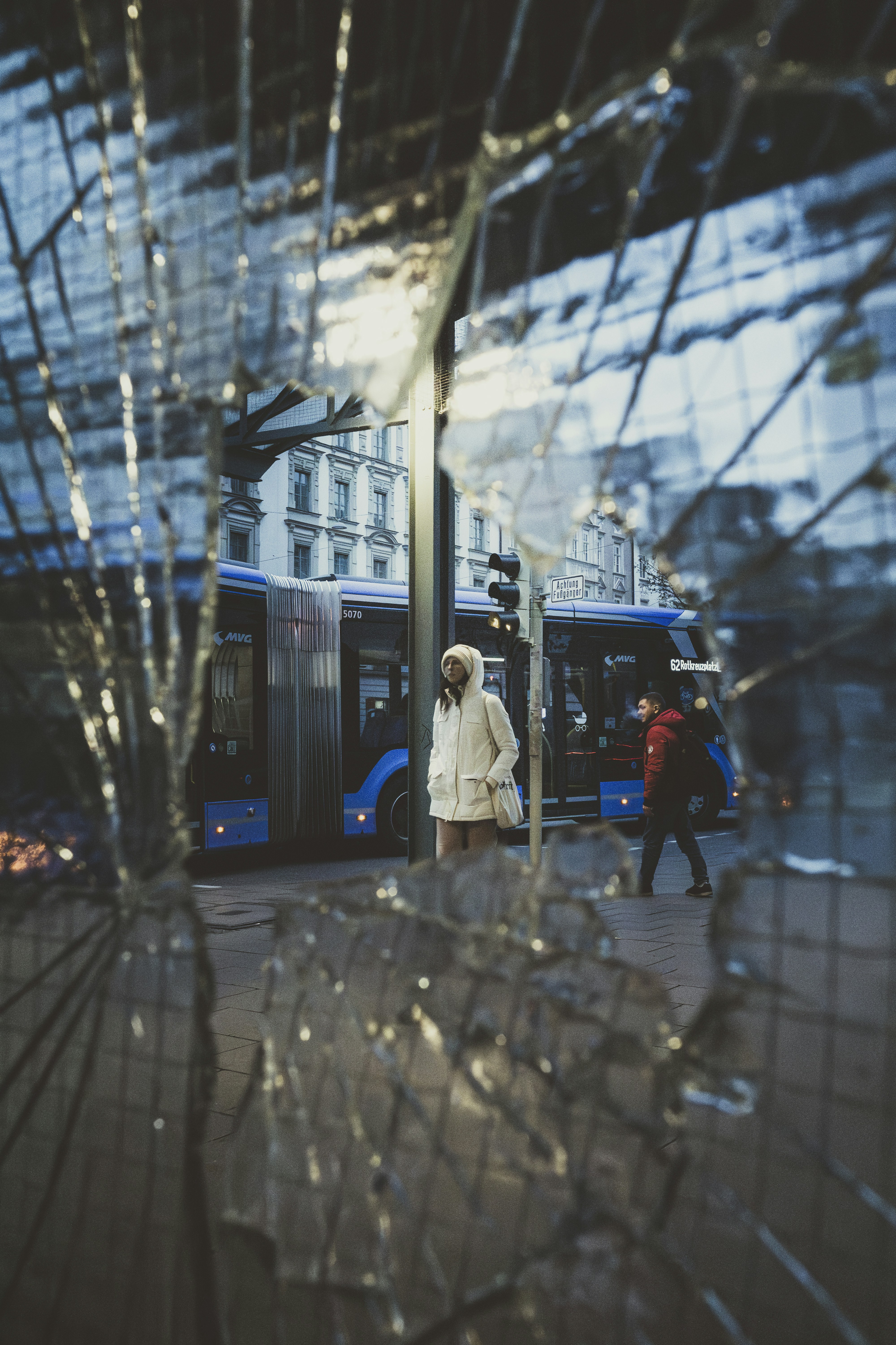 Femme en blouse blanche près d’un bus à travers une vitre brisée photo ...