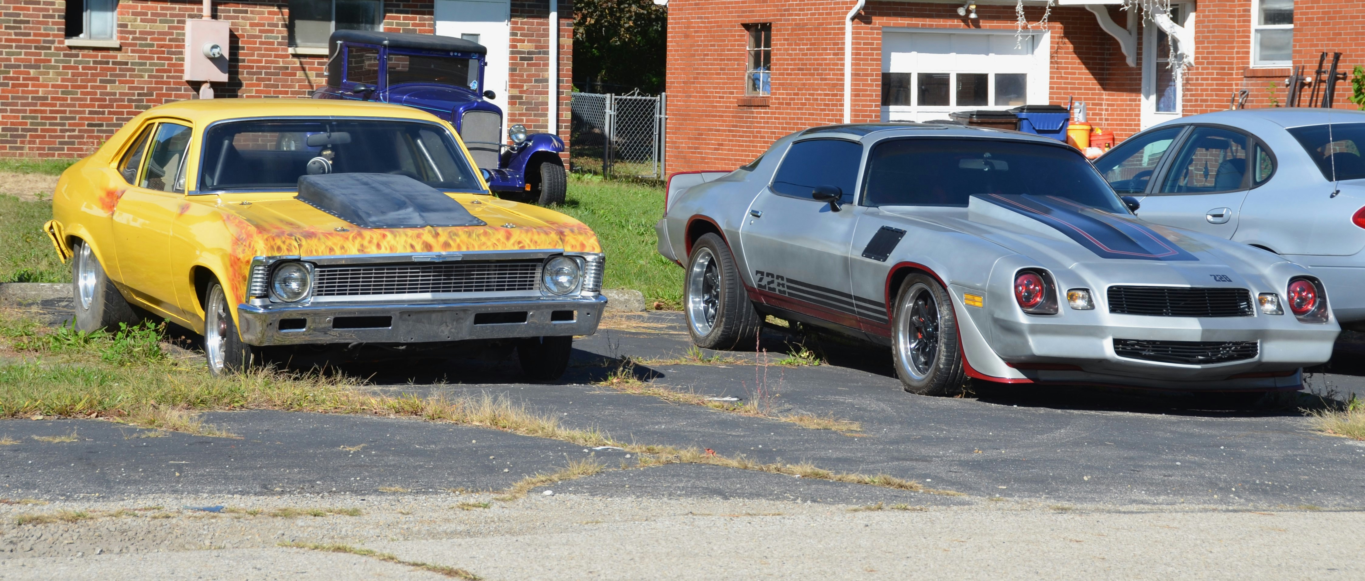 Dos muscle cars clásicos estacionados afuera de un edificio. foto ...