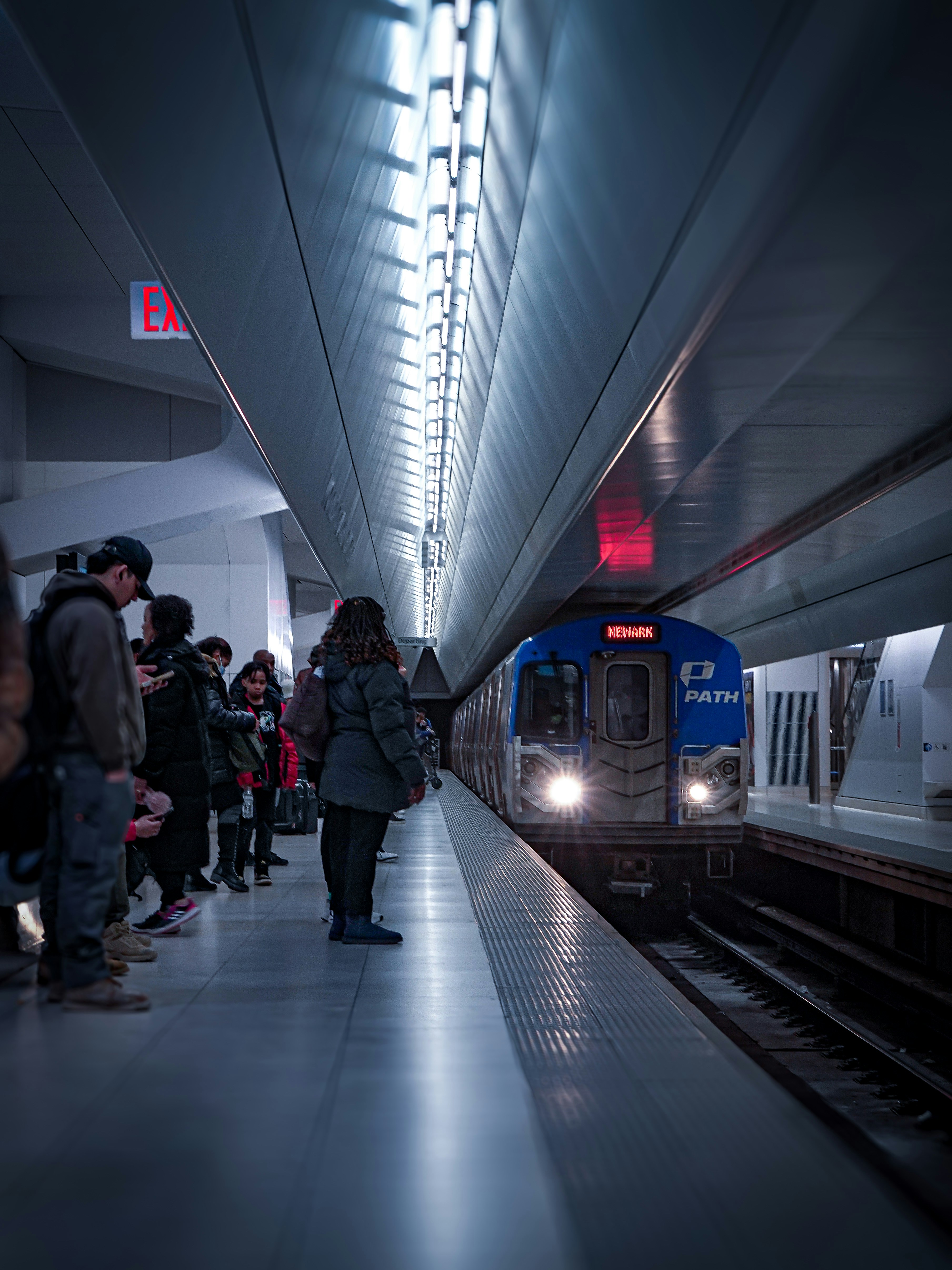 The Path Breaker - SMNYCMan | People wait for a train at a modern subway station.