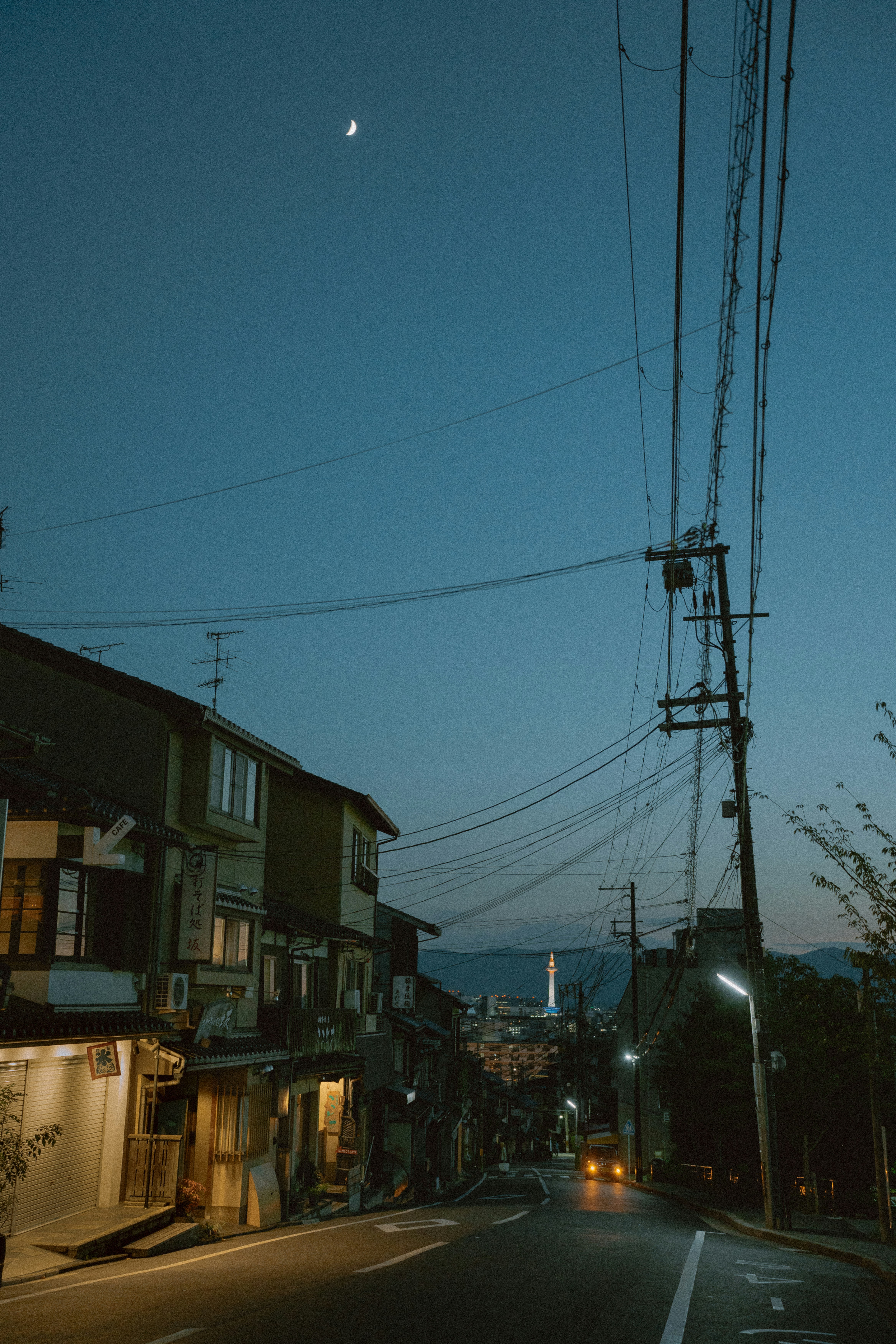 Street scene with buildings and power lines at dusk