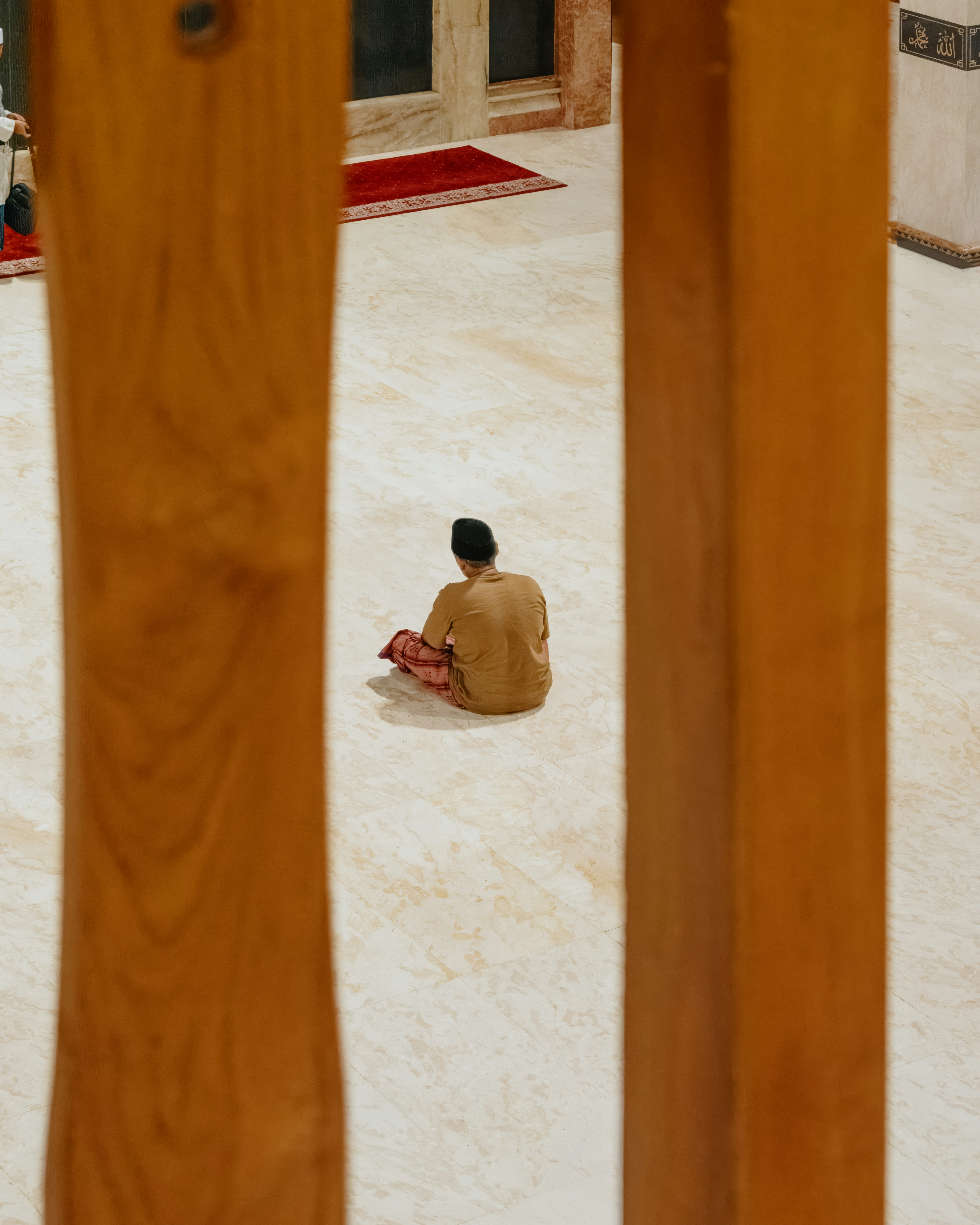 Man sitting on floor wearing kufi cap