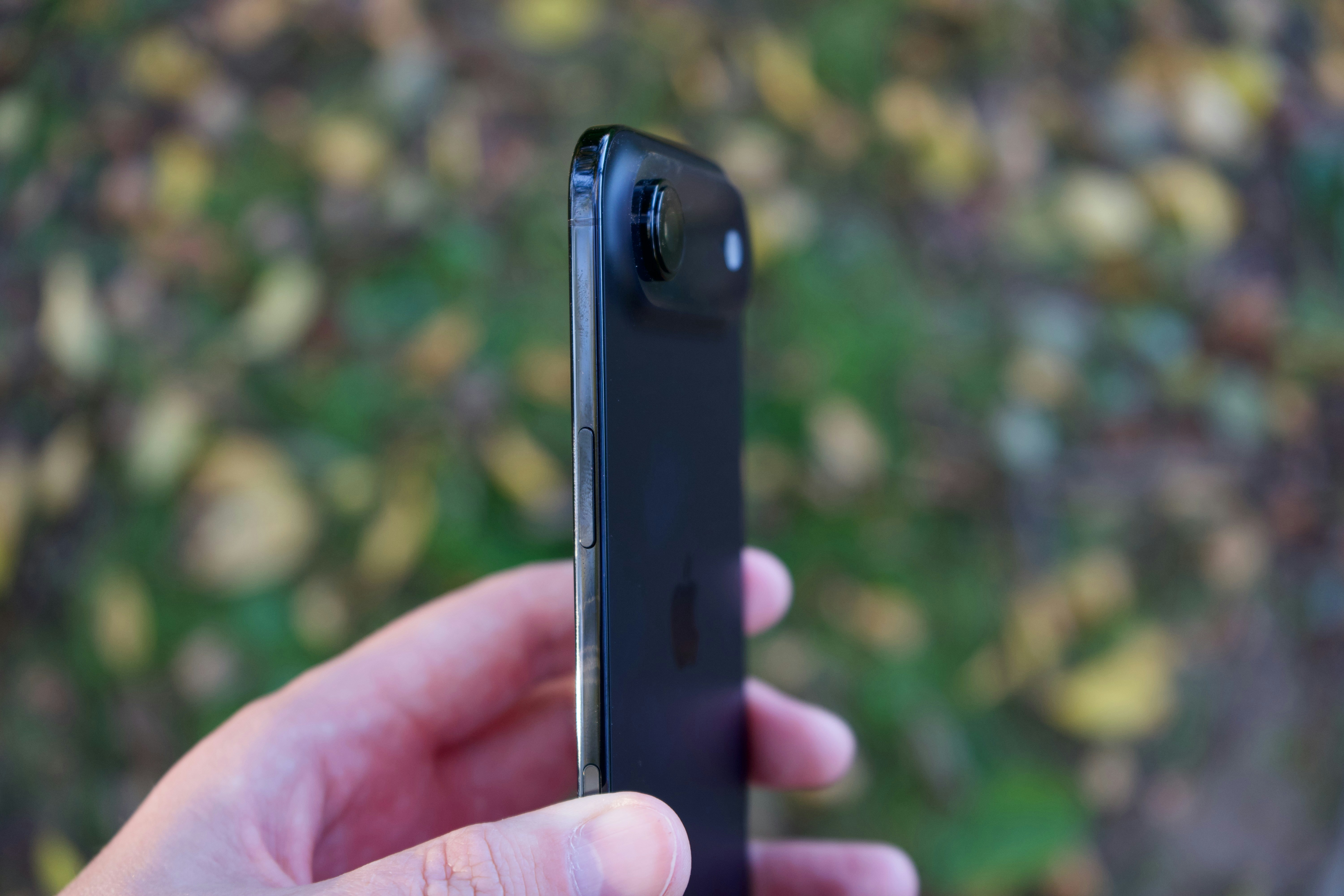 Autumn Grip: A Handful of Tech Against a Blurred Leafscape