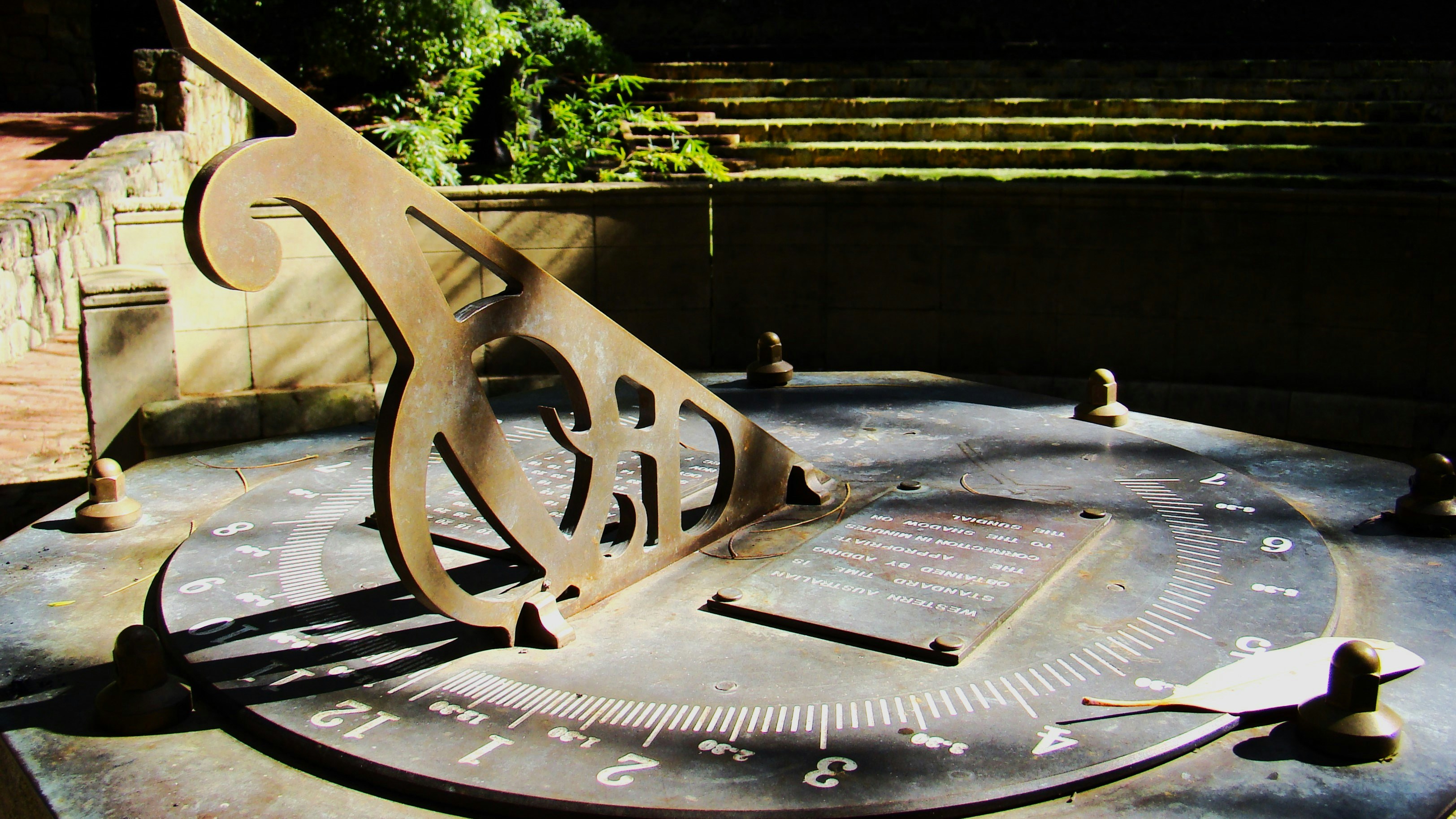 A weathered sundial in a garden setting.