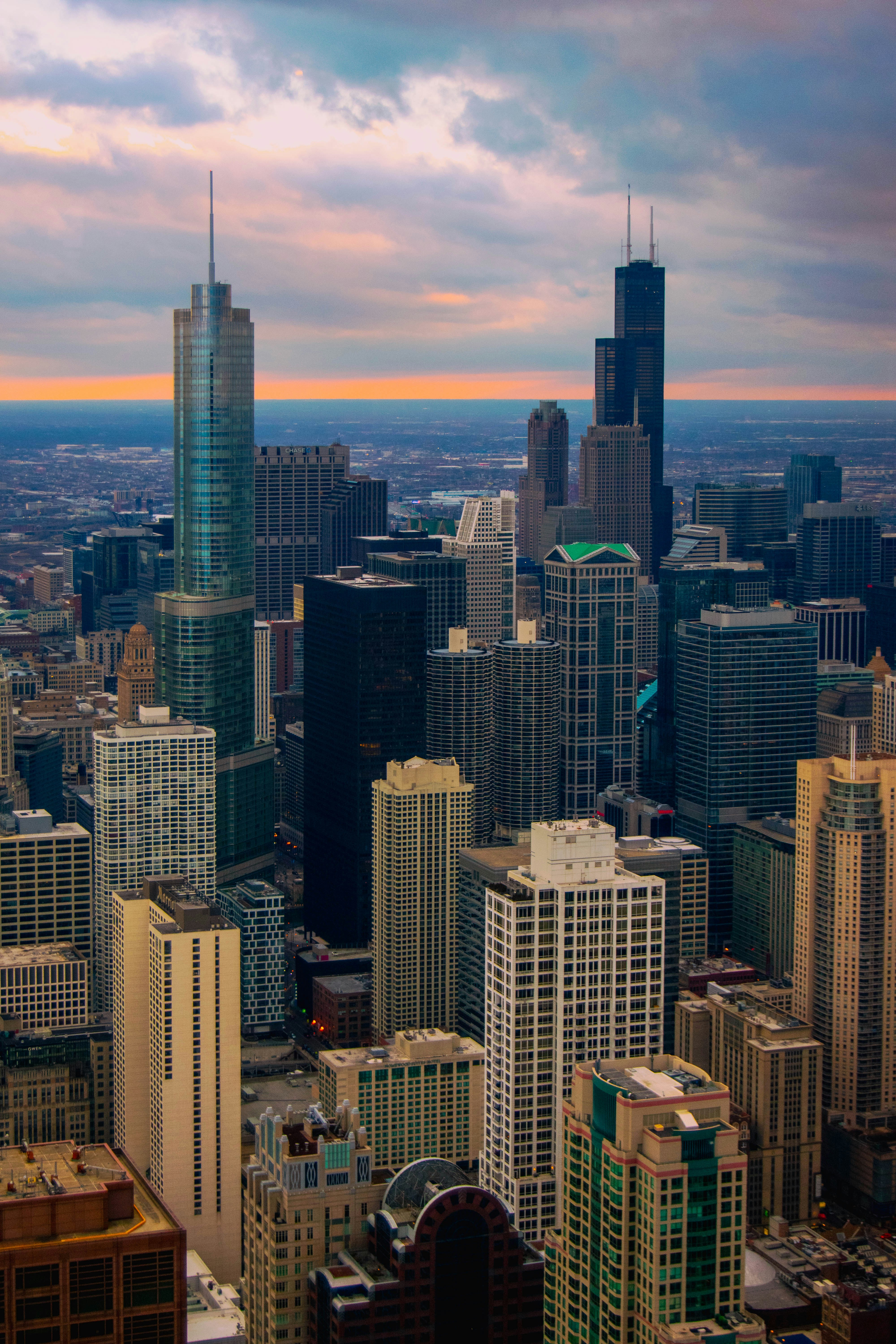 Aerial view of a bustling city skyline featuring towering skyscrapers against a twilight sky.