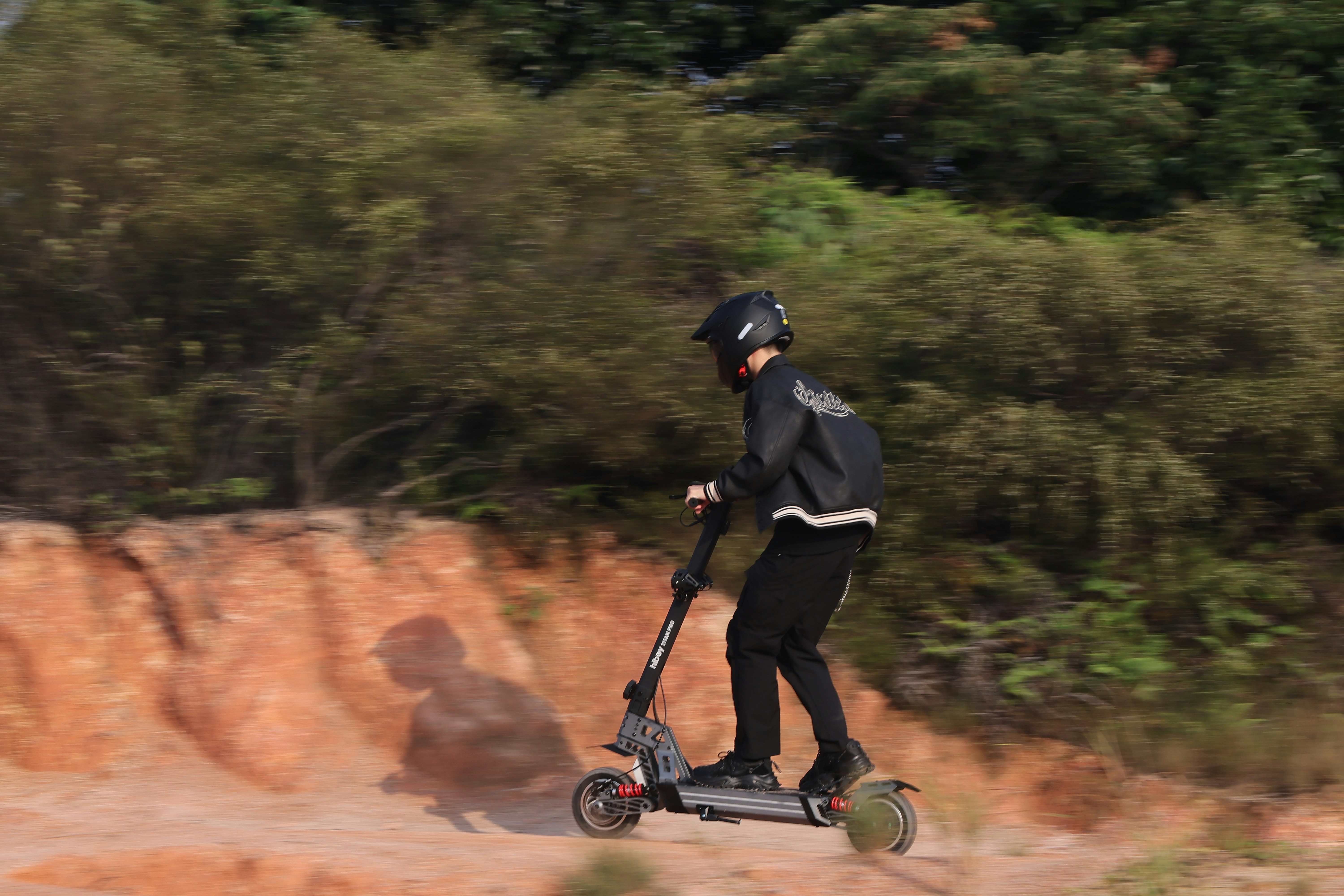 Dust and Velocity: A Rider on an Electric Scooter in Motion