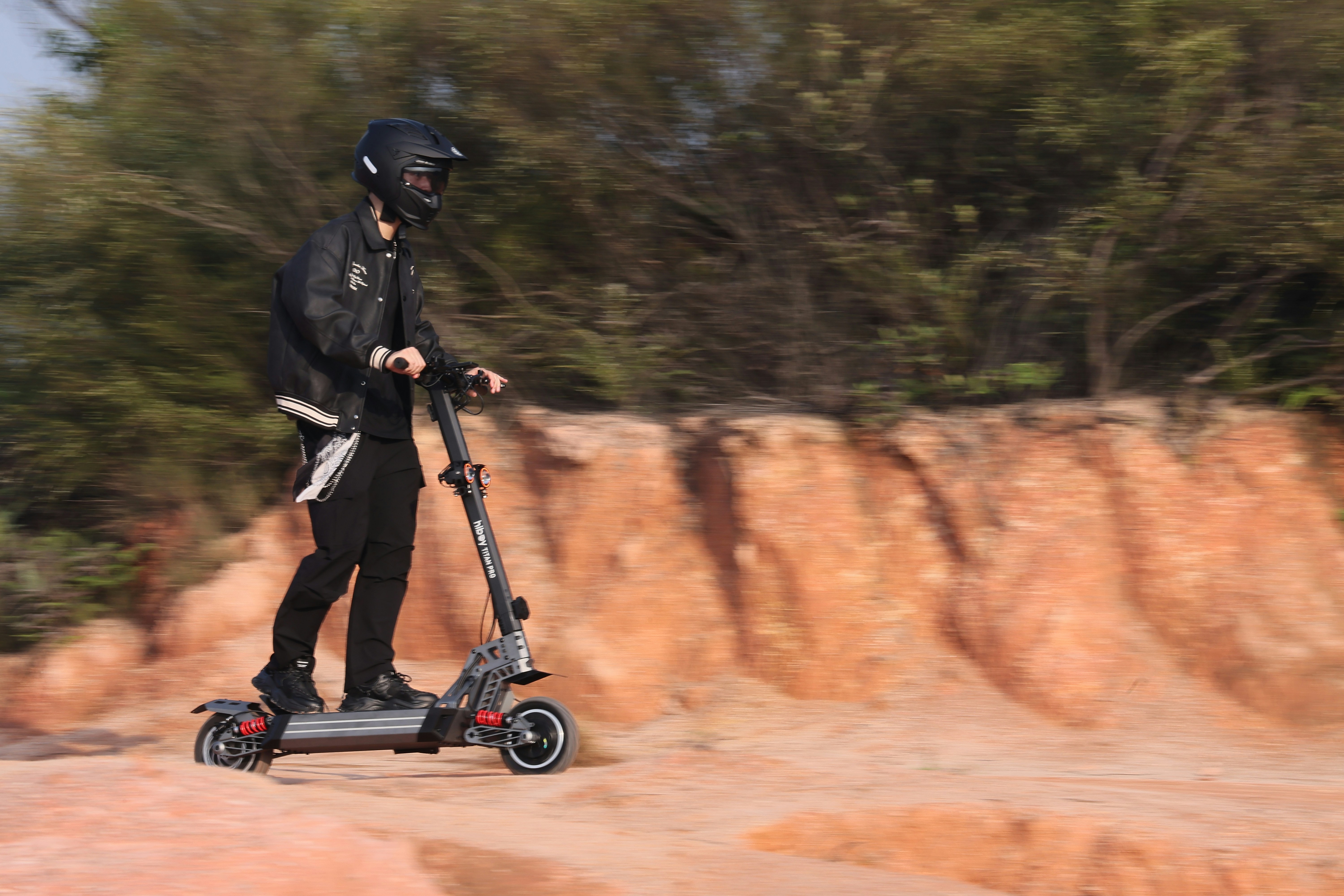 Rider navigating a rugged terrain on an electric scooter, showcasing dynamic movement and outdoor exploration.